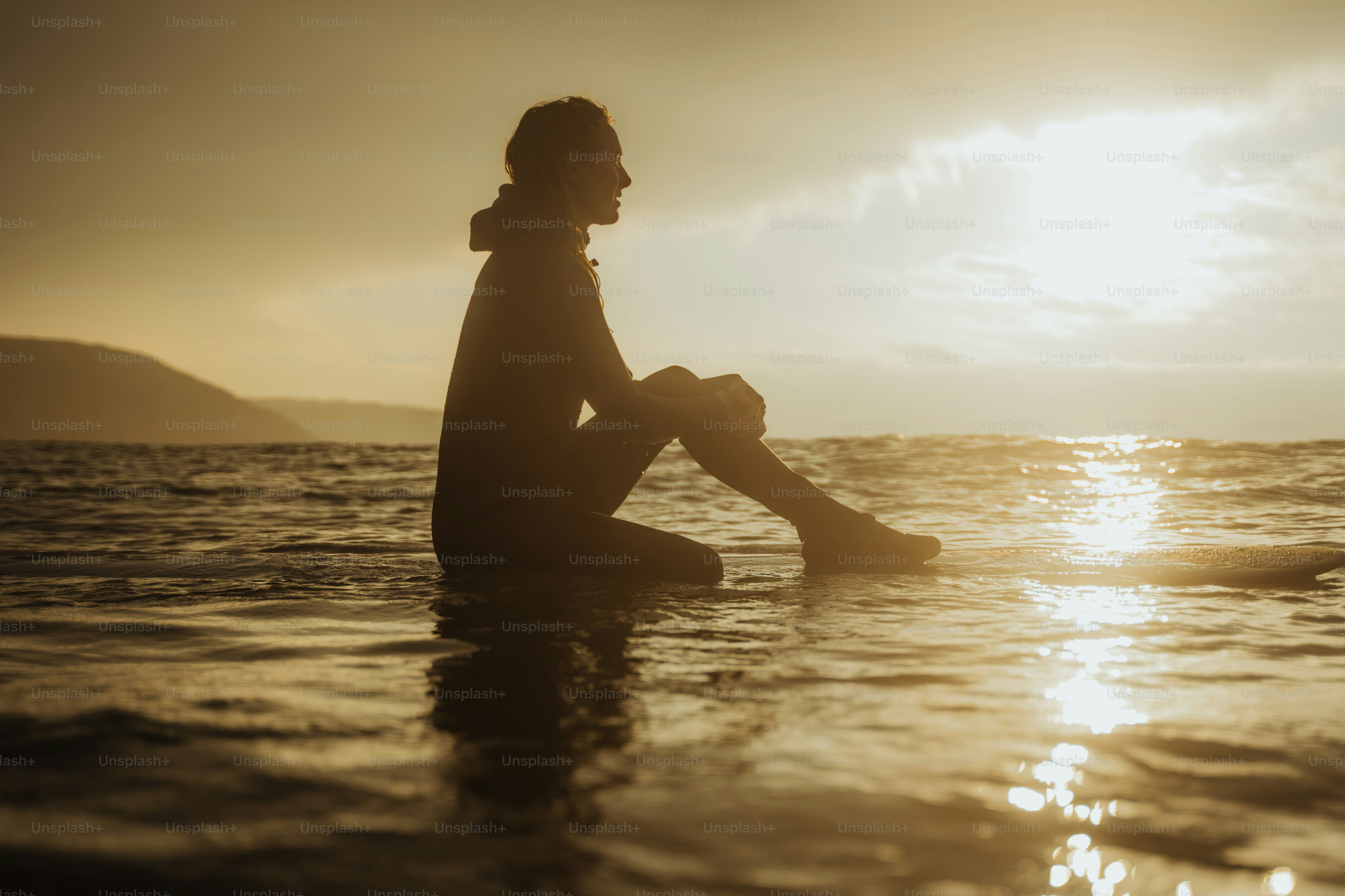 Una persona sentada en una tabla de surf en el agua foto – Imagen de ...