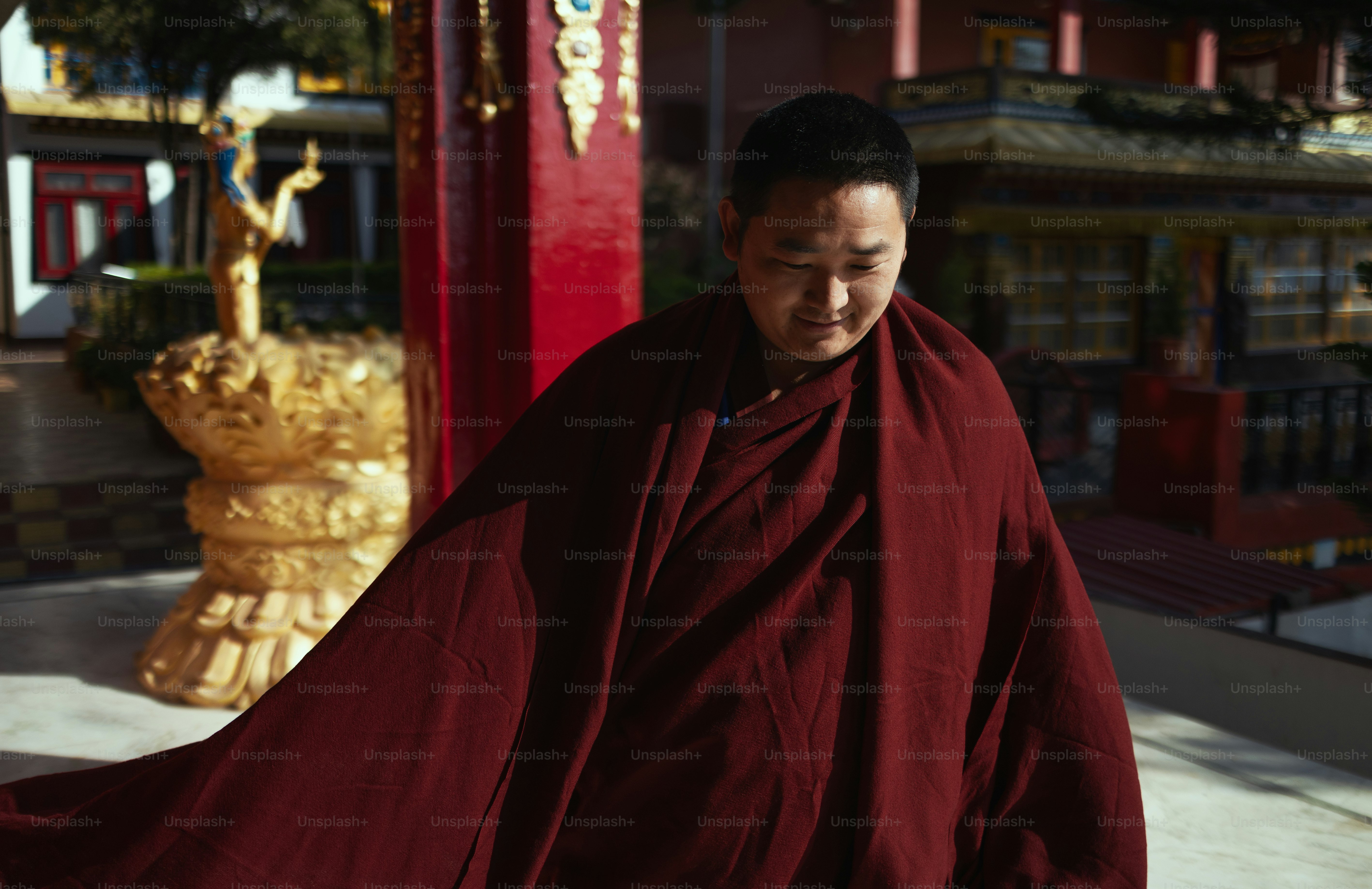 A person in a red robe walking down a street photo – Monk Image on Unsplash
