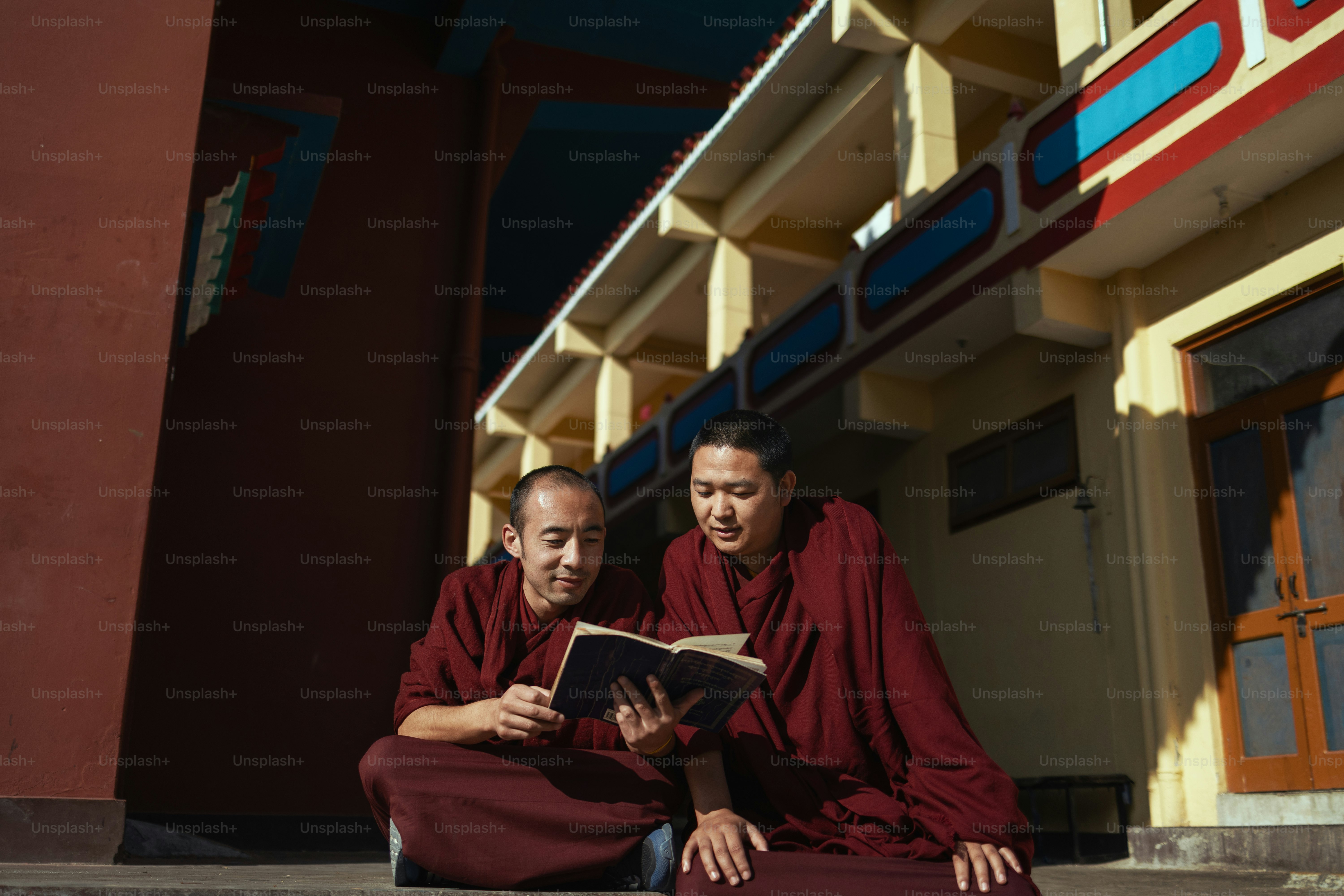Two monks sitting on steps reading a book photo – Indigenous people ...