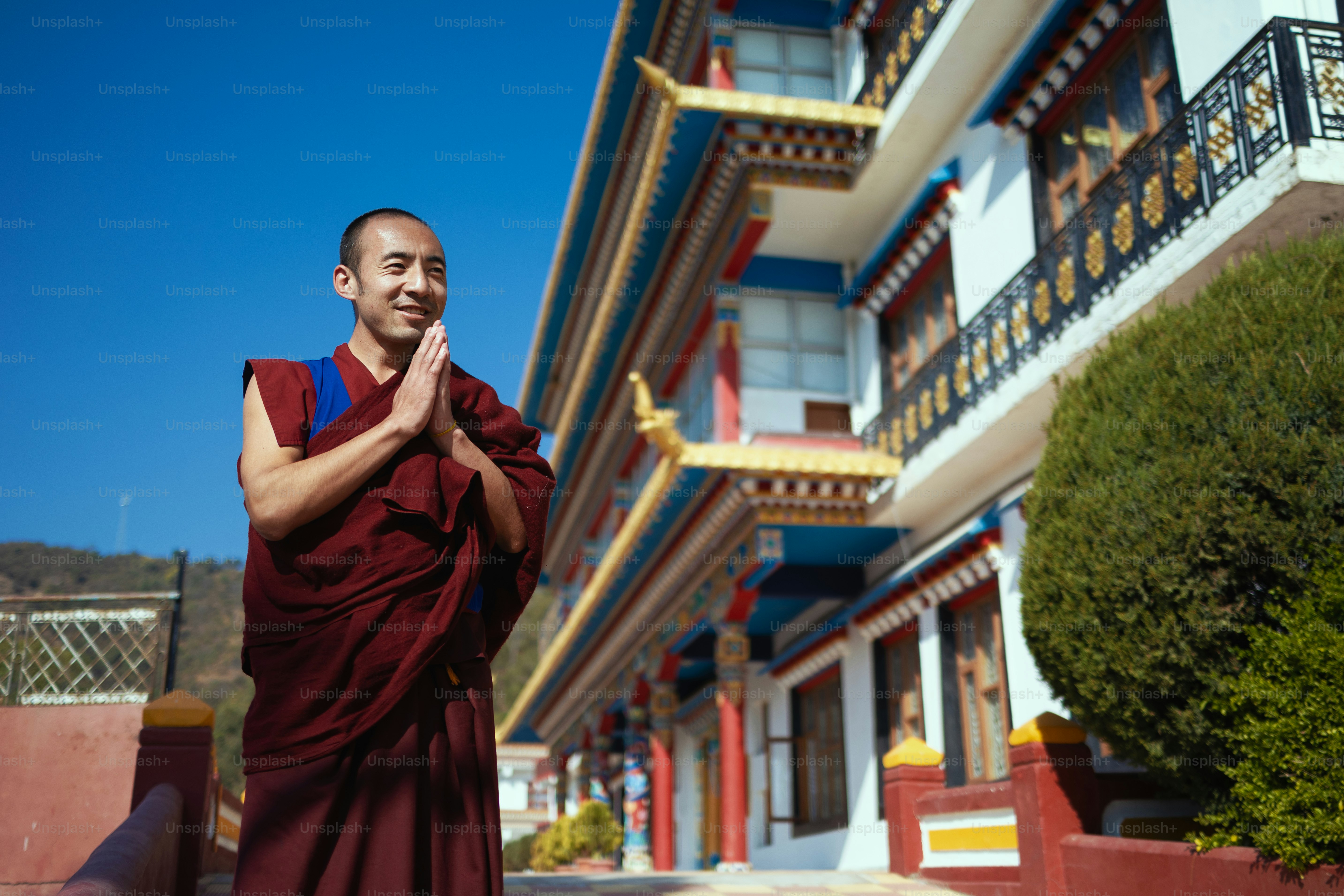 A man in a red robe standing in front of a building photo – The menri ...