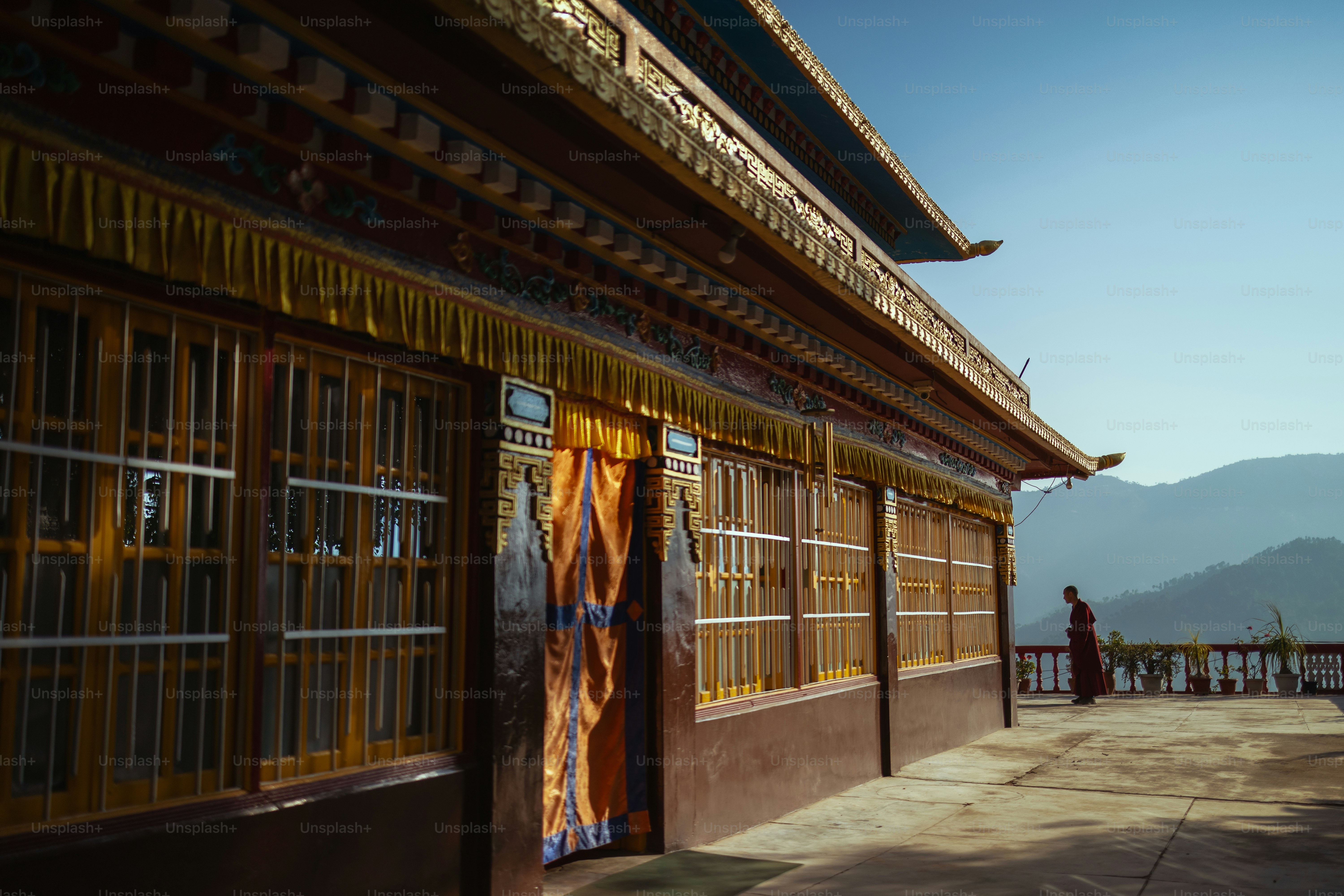 A building that has a lot of windows on it photo – The menri monastery ...