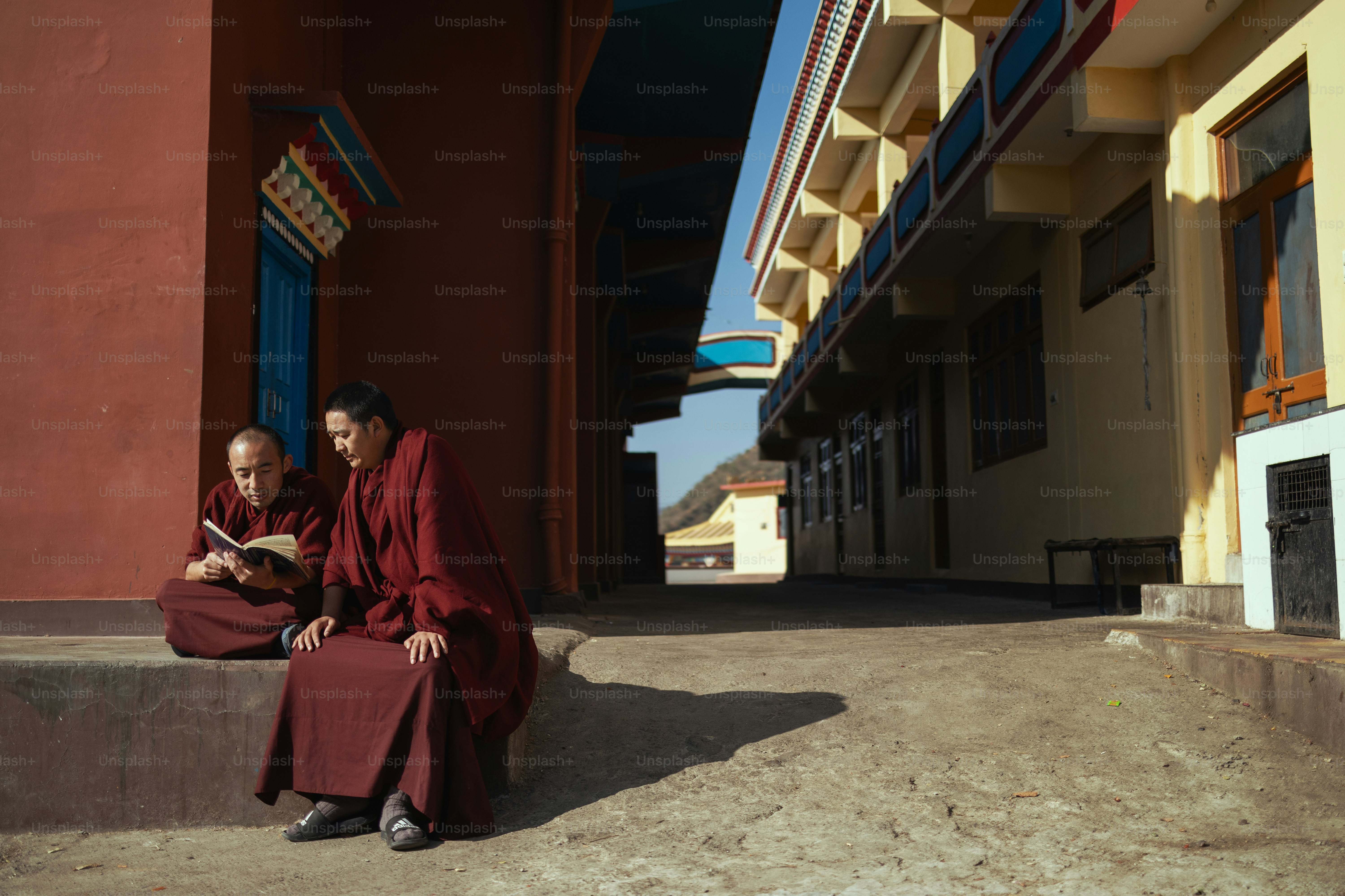 A couple of men sitting on a step next to each other photo – The menri ...