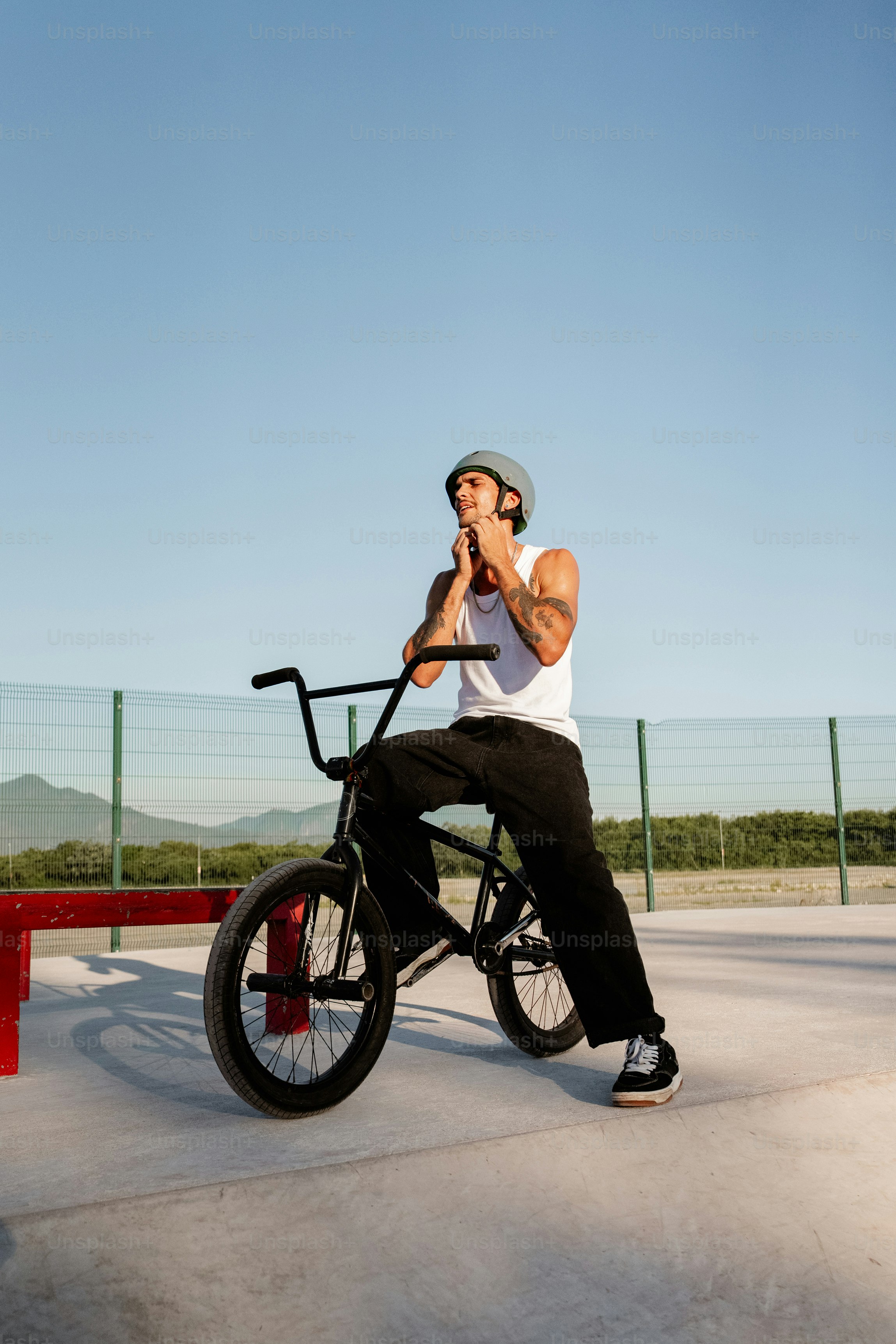 A man riding a bike over a red rail photo – Bike trends Image on Unsplash