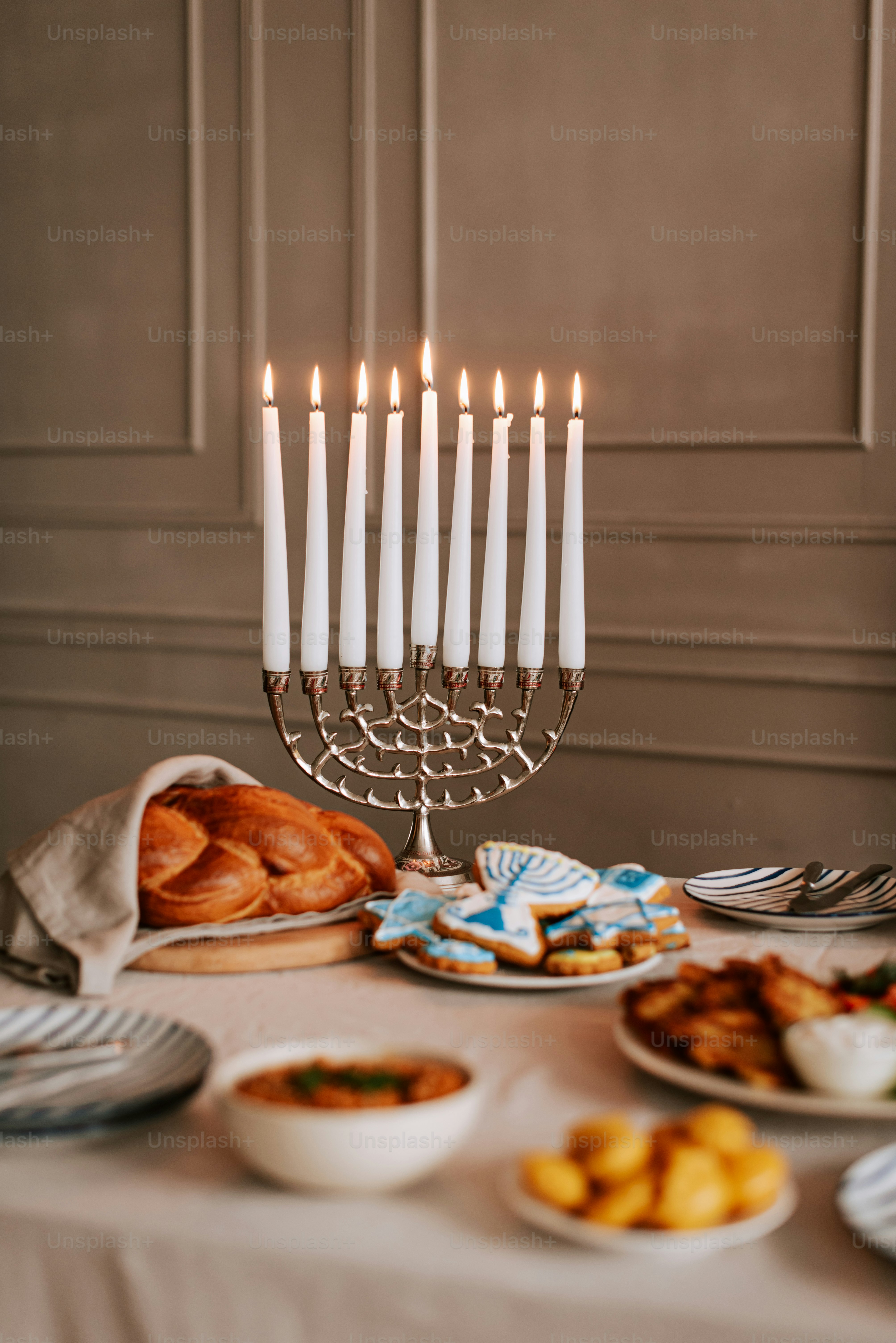 A table topped with plates of food and a menorah photo – Hanukkah food ...