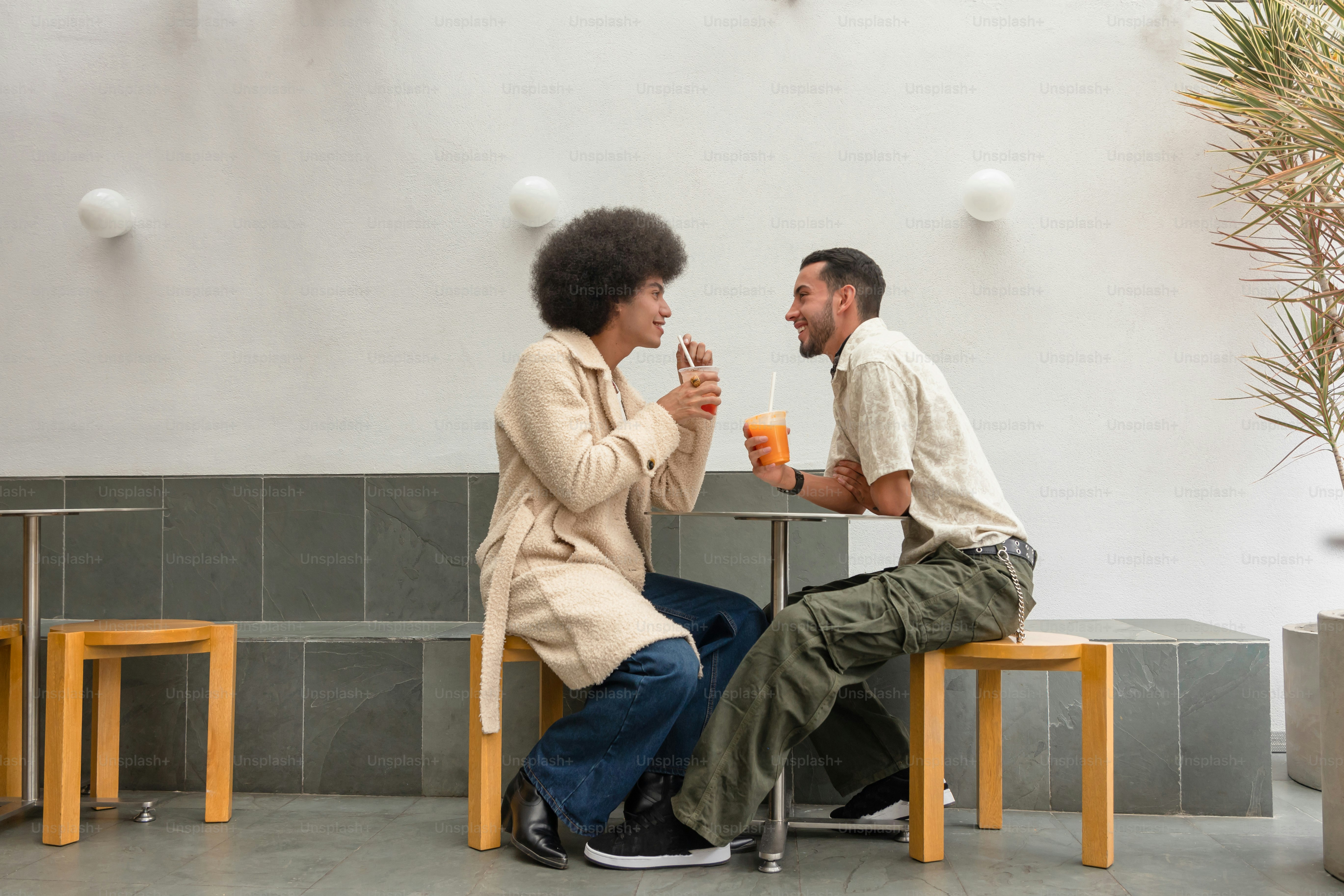 A couple of people sitting at a table photo – Lgbtqia Image on Unsplash