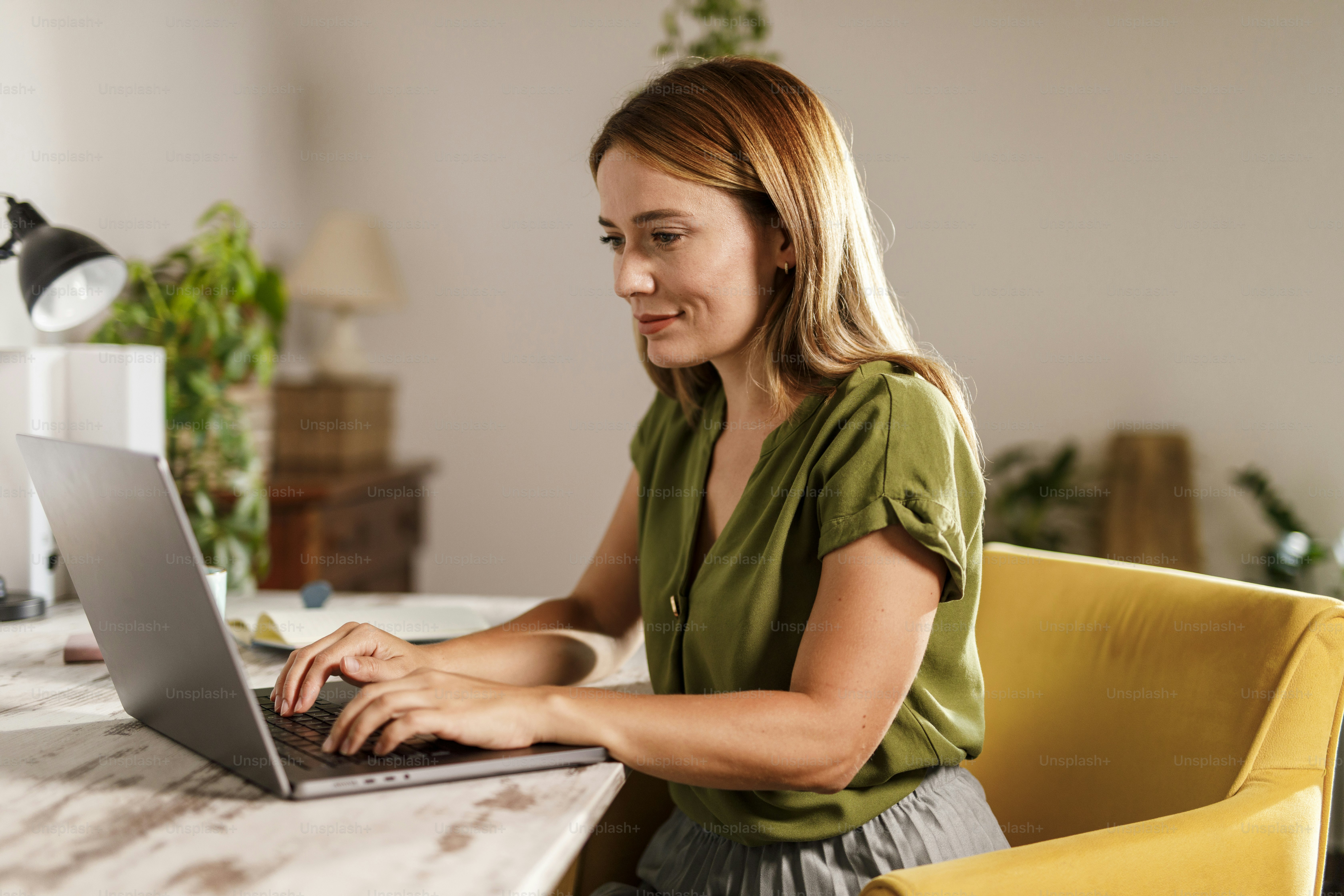 Portrait of diligent mid adult woman using laptop when working on a ...