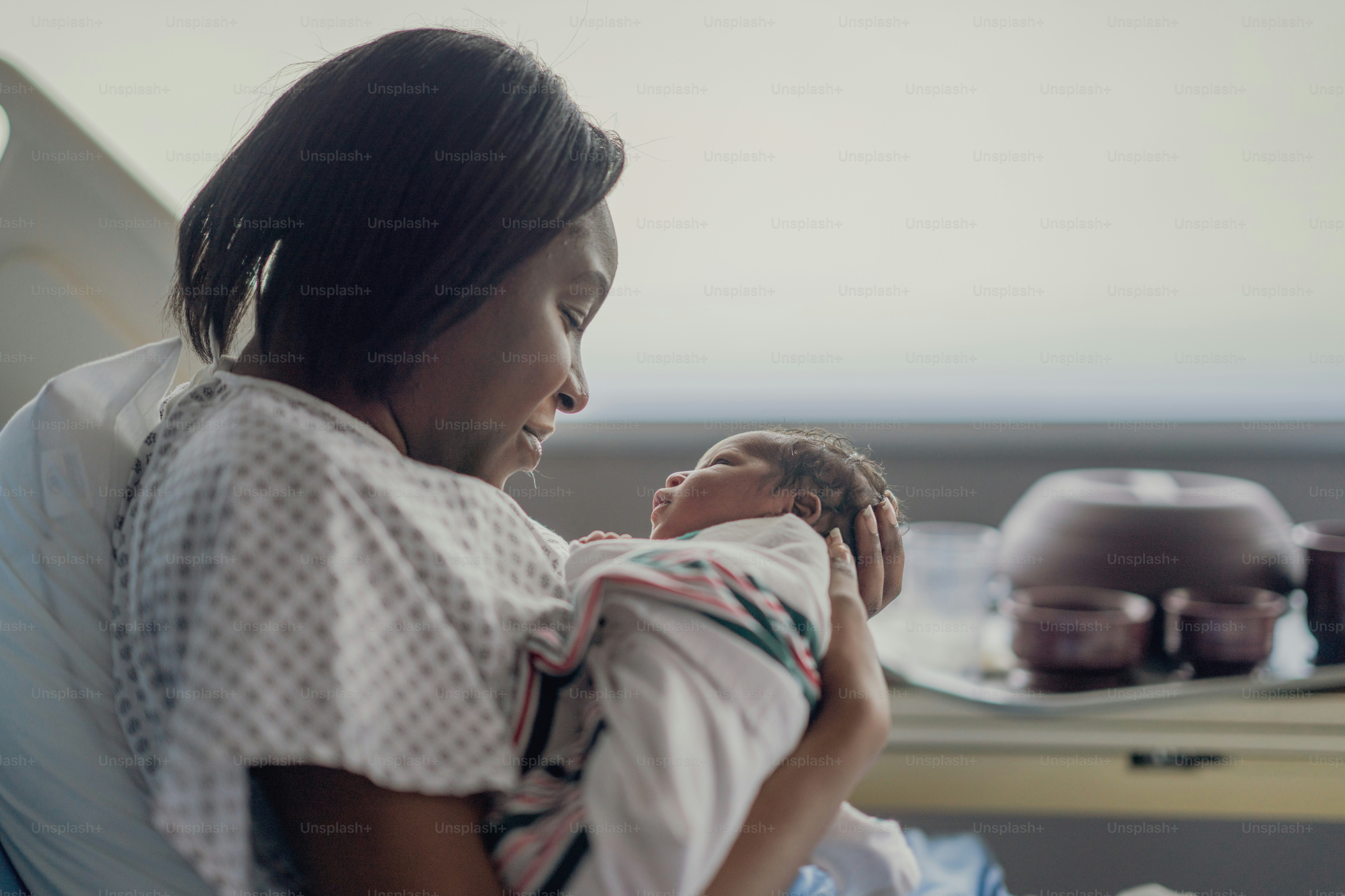 A new Mother, of African decent, proudly holds her newborn baby out in ...