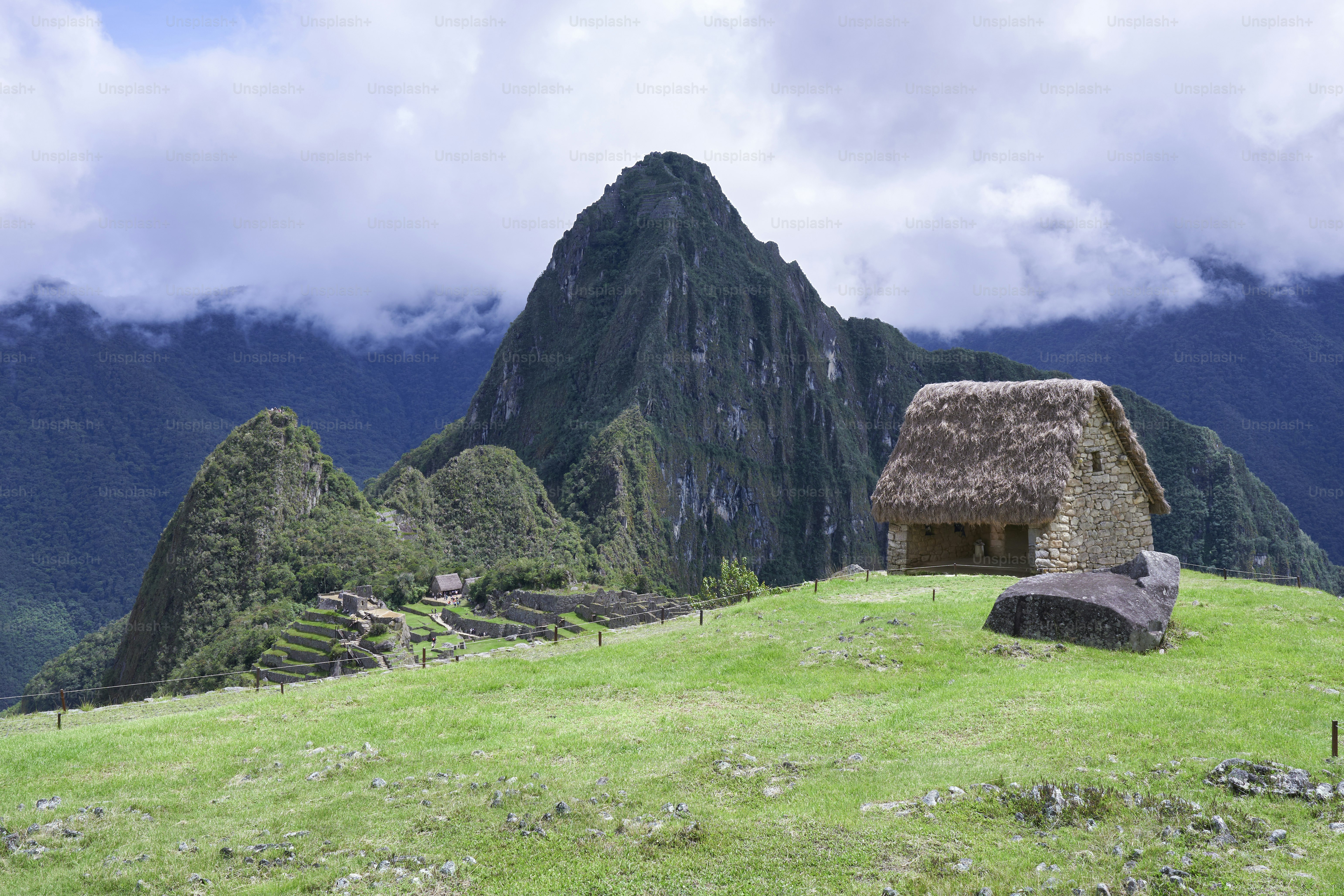 A small house in Machu Picchu focusing on Huina Picchu on a foggy day ...