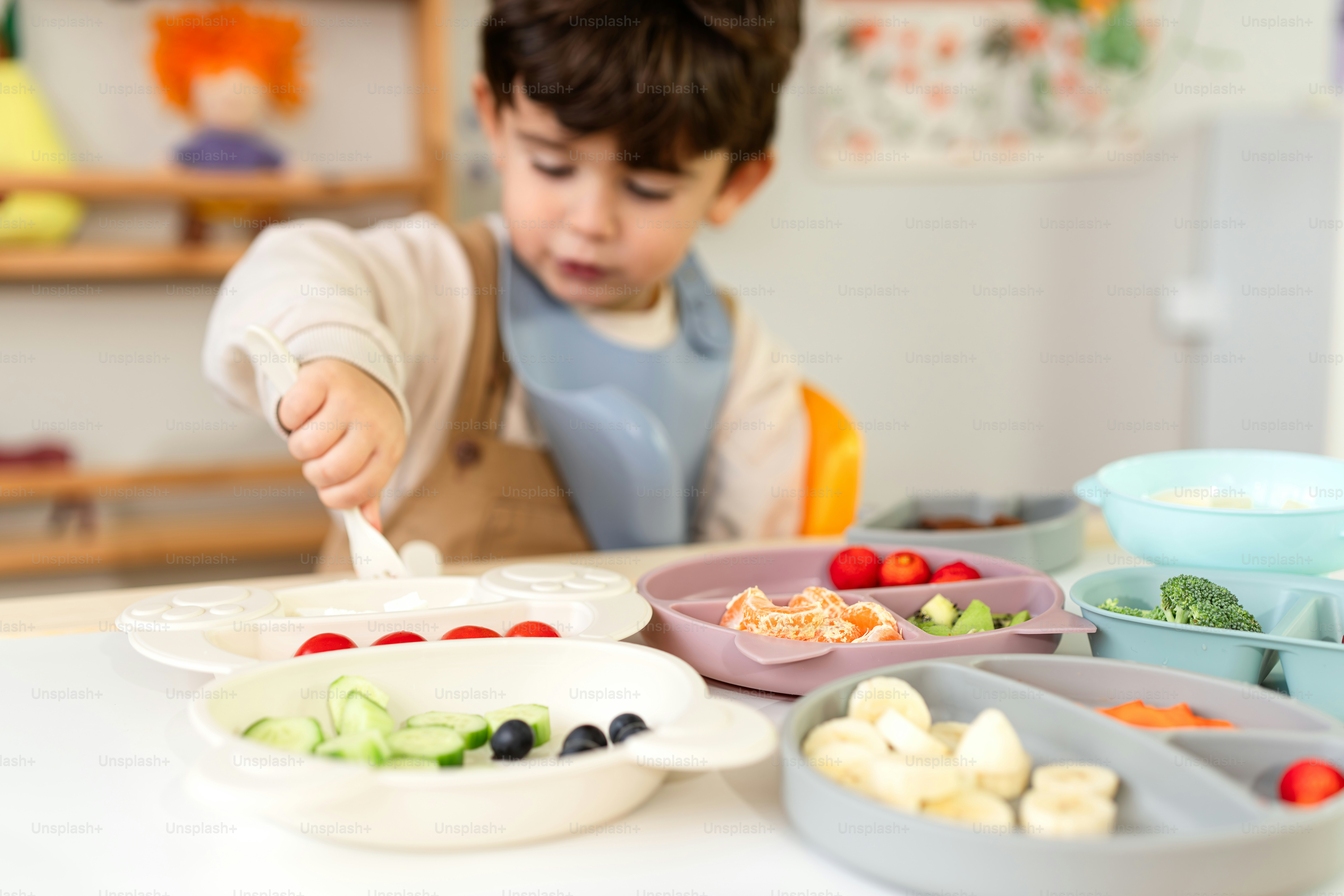 A little boy that is standing in front of a table photo – Food Image on ...