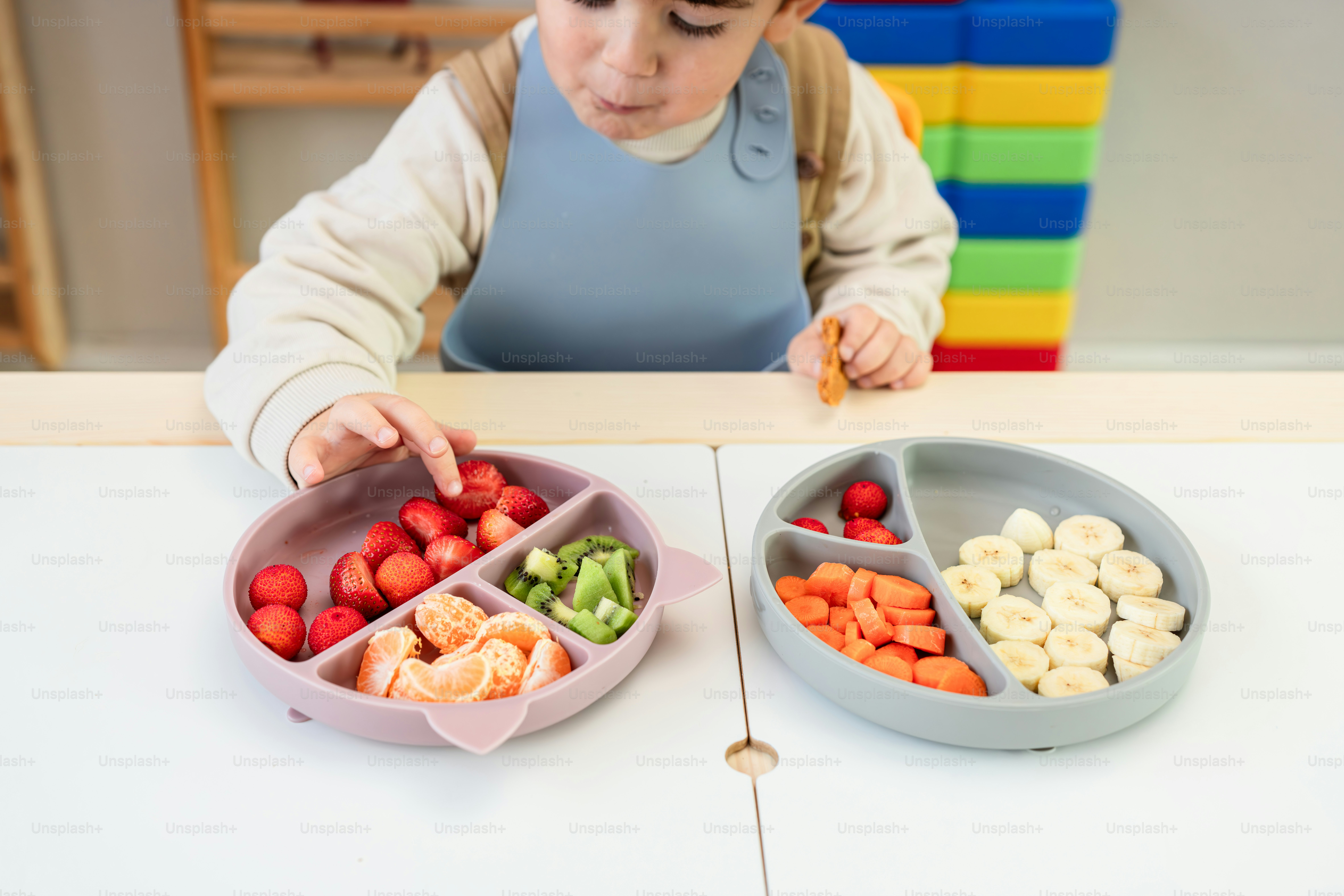 A little boy that is standing in front of a table photo – Food Image on ...