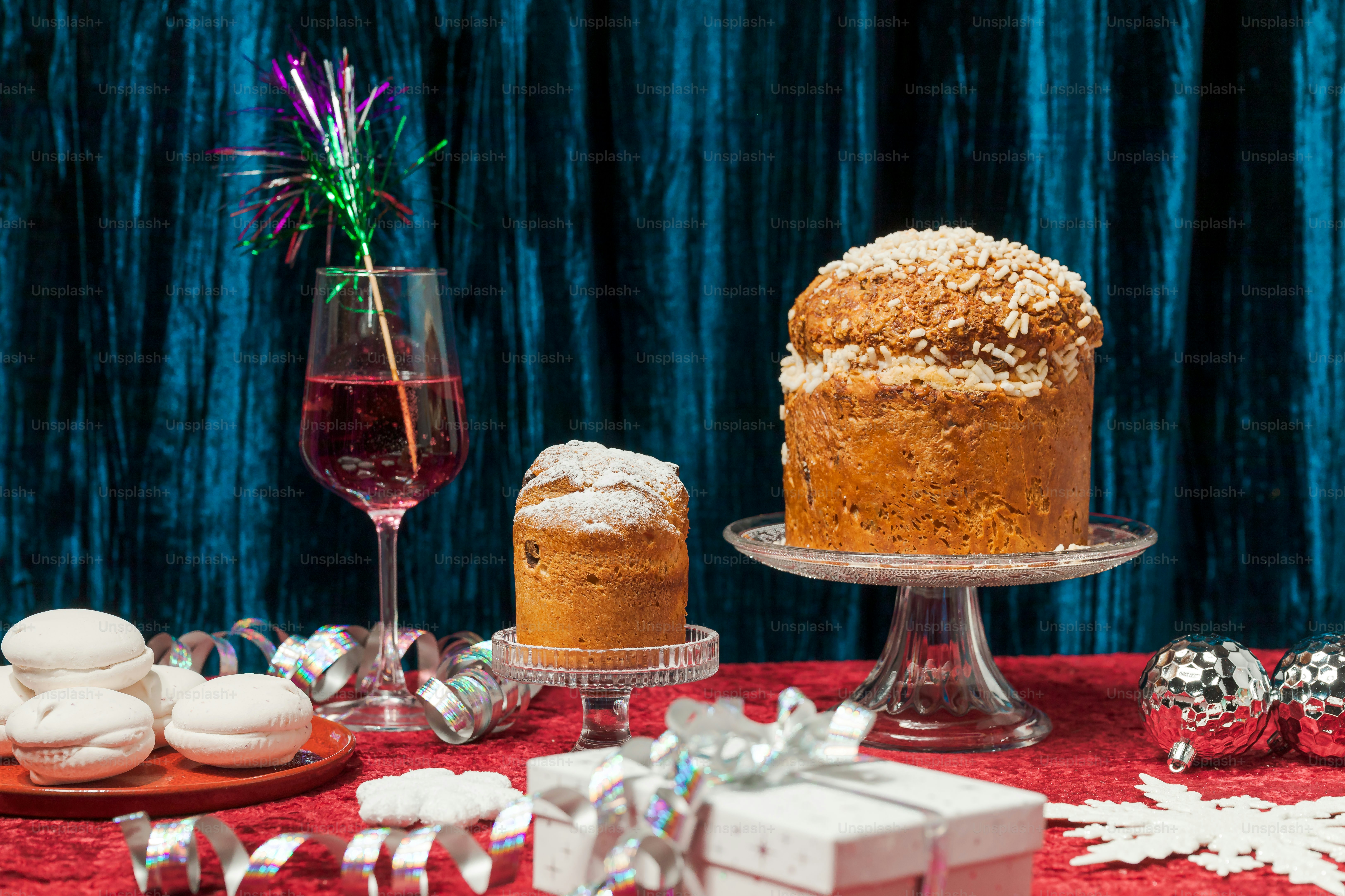 A table topped with cakes and desserts on top of a red table cloth ...