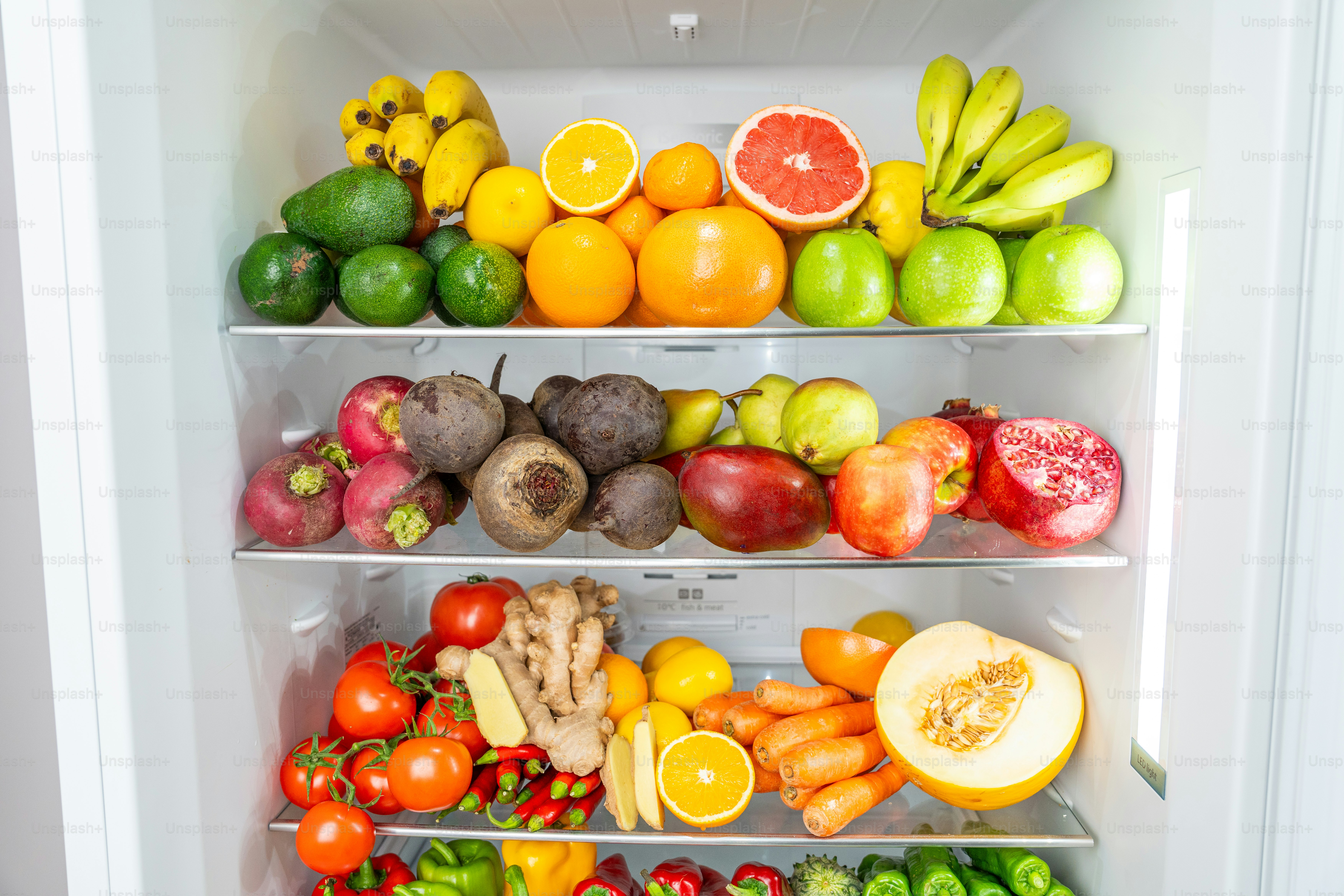 A refrigerator filled with lots of different types of fruits and ...