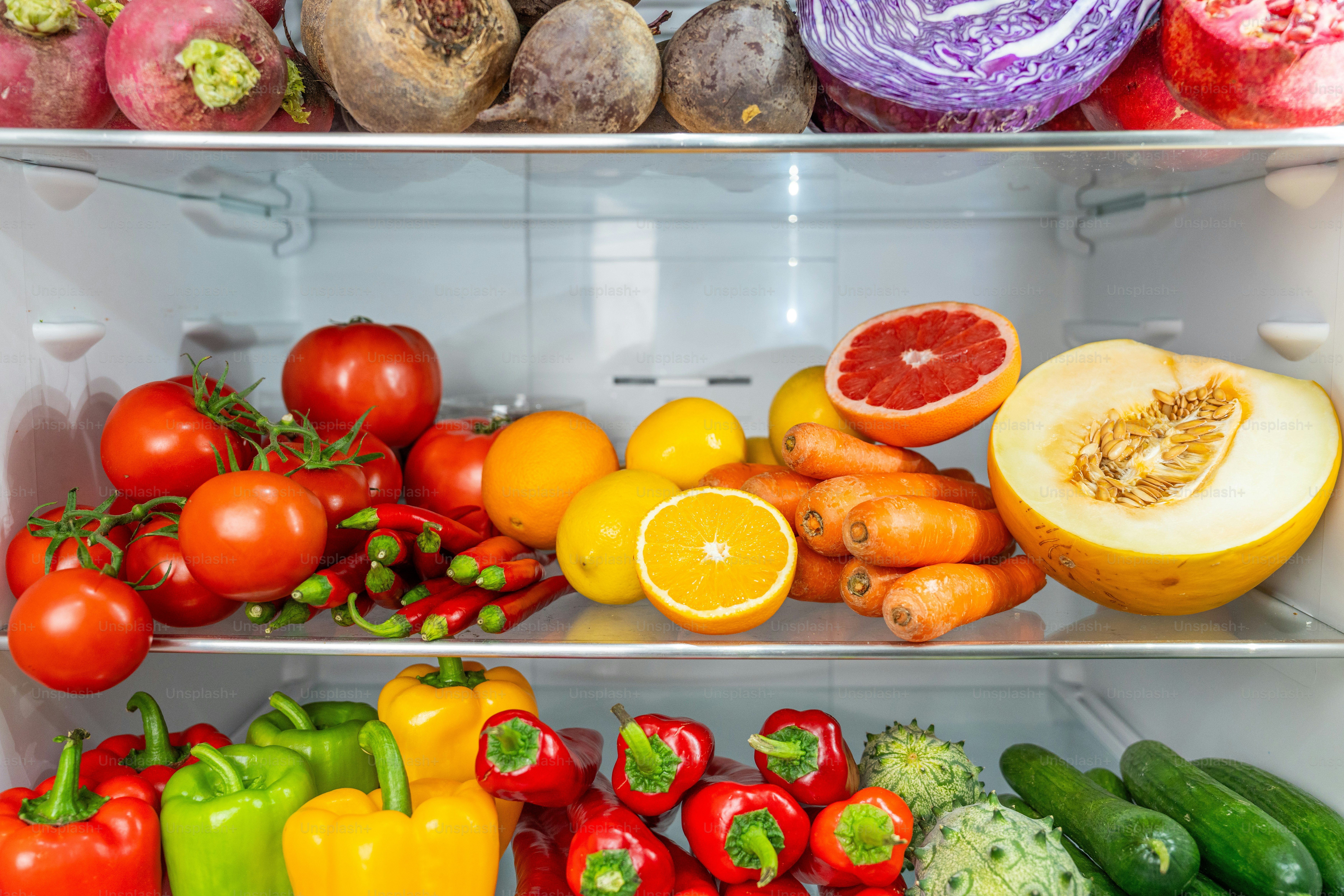A refrigerator filled with lots of different types of fruits and ...