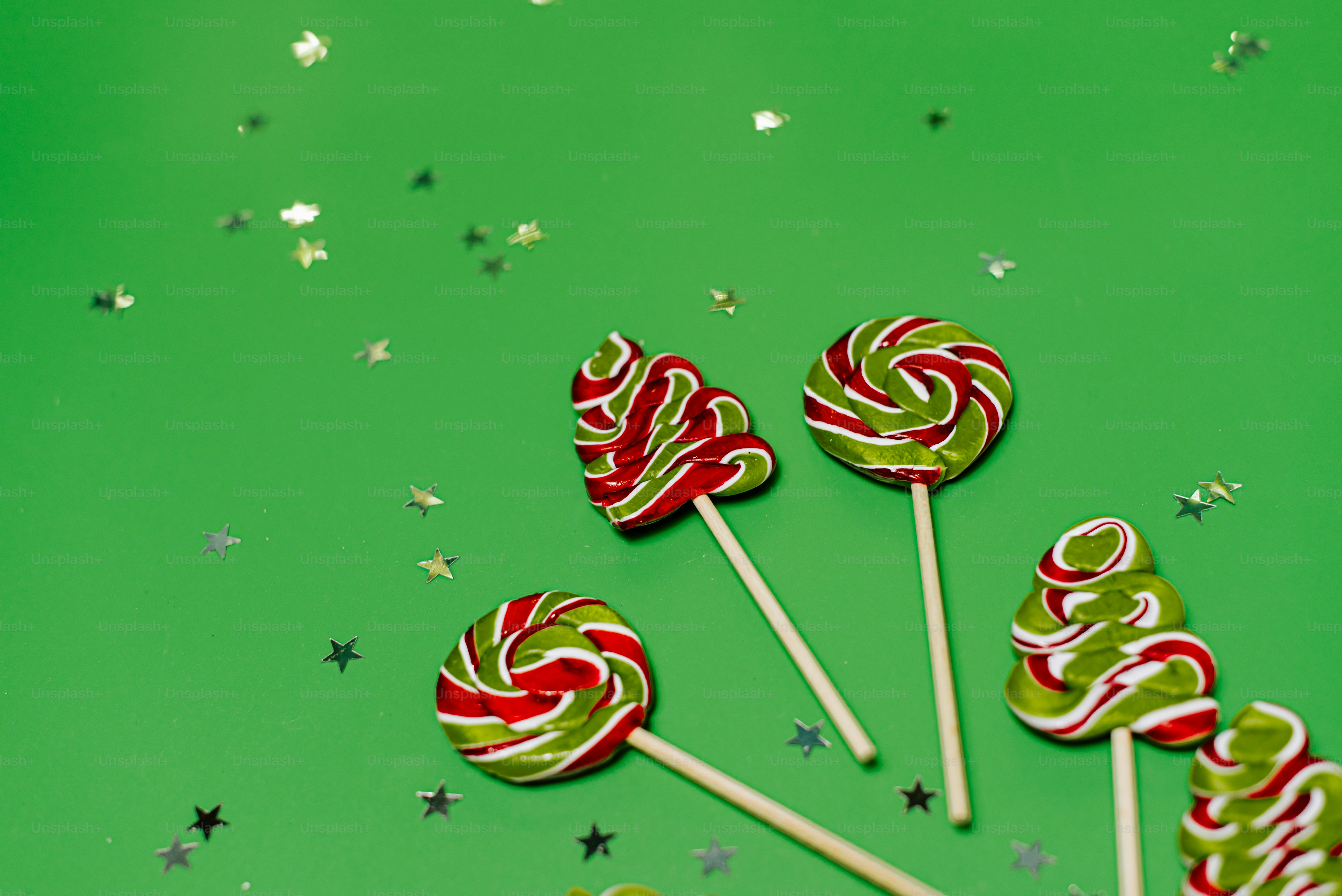 A group of lollipops sitting on top of a green table photo – Candy ...