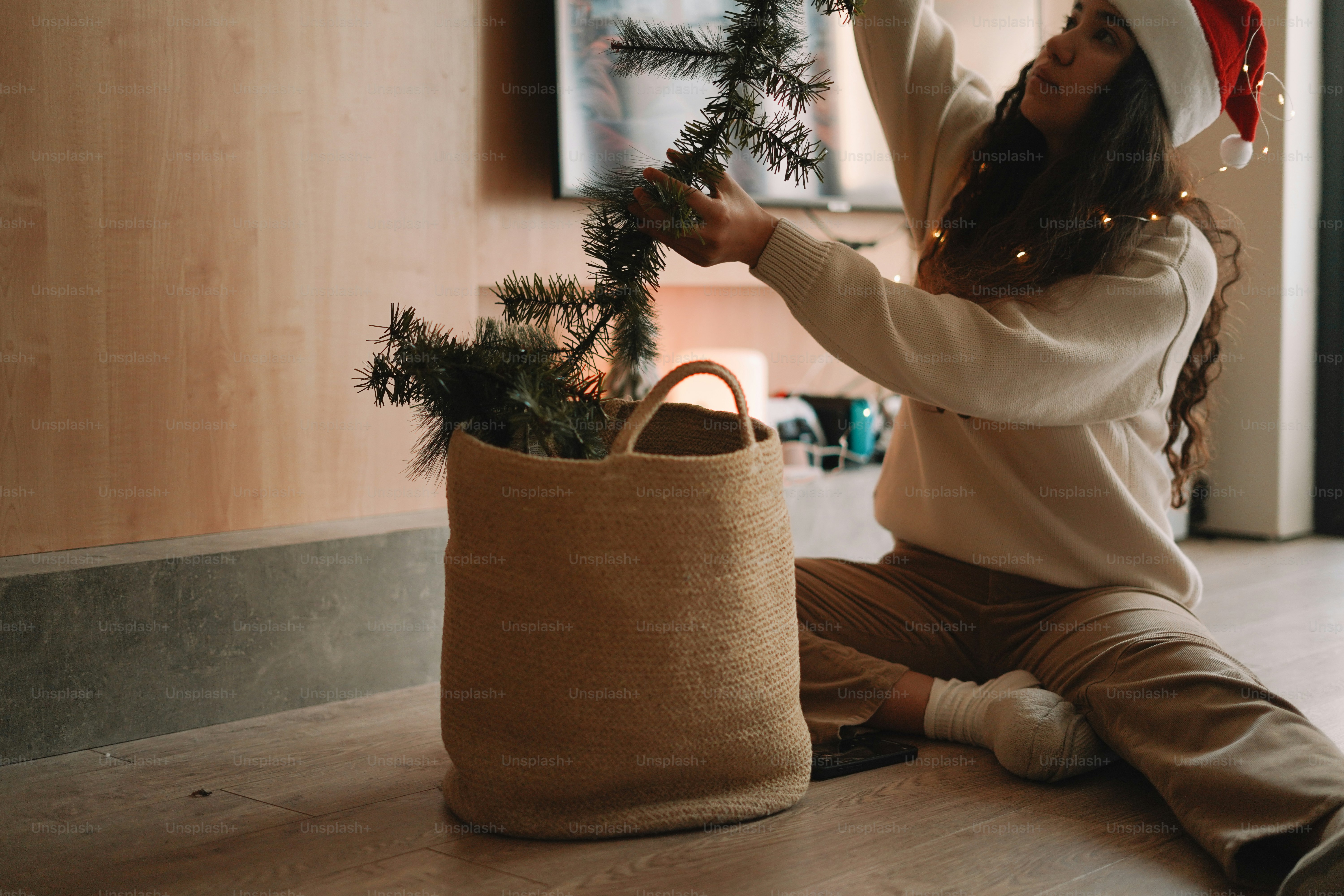 A little girl sitting on the floor with a christmas tree in a bag photo ...