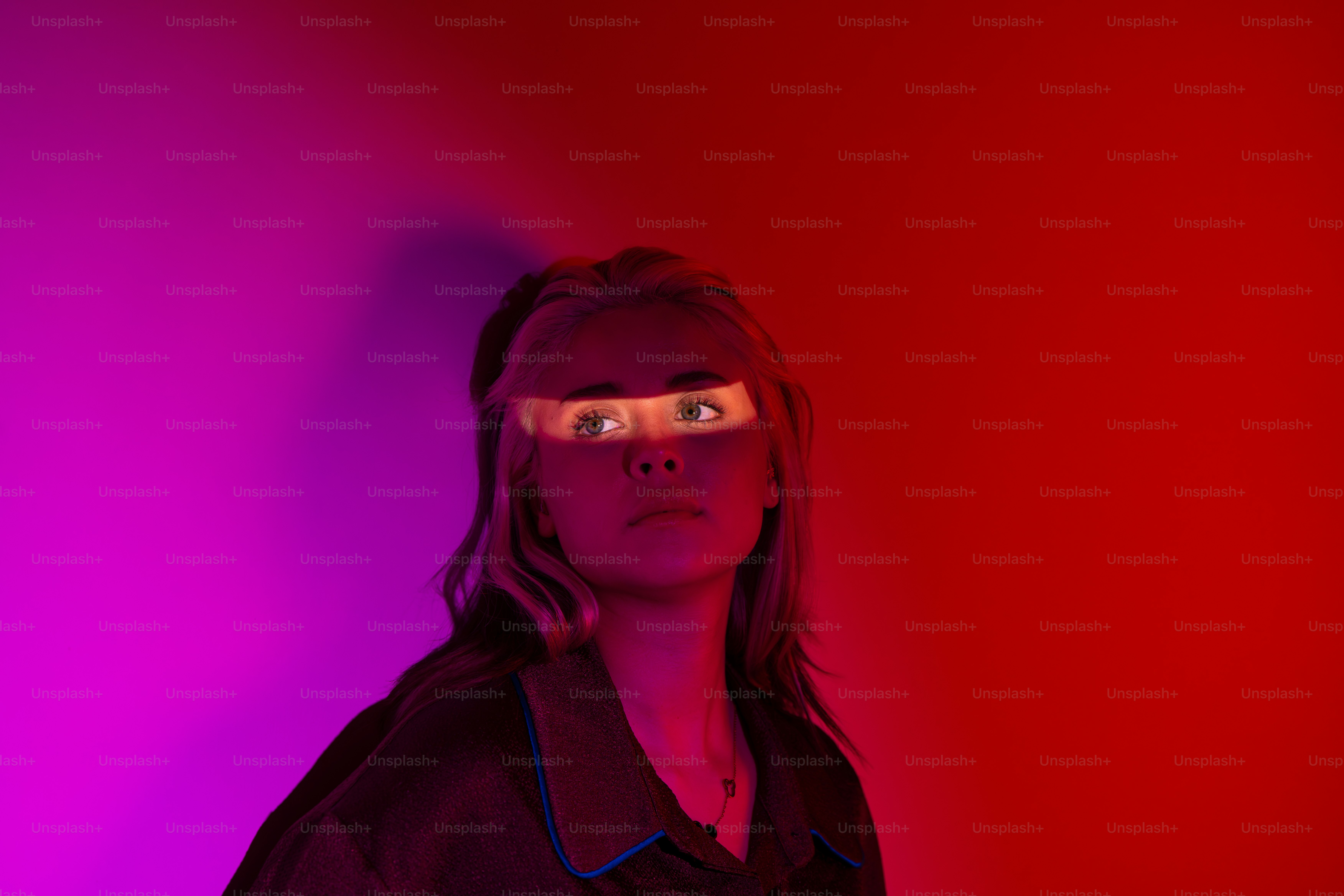 A woman with a blindfolded eye standing in front of a red and purple ...