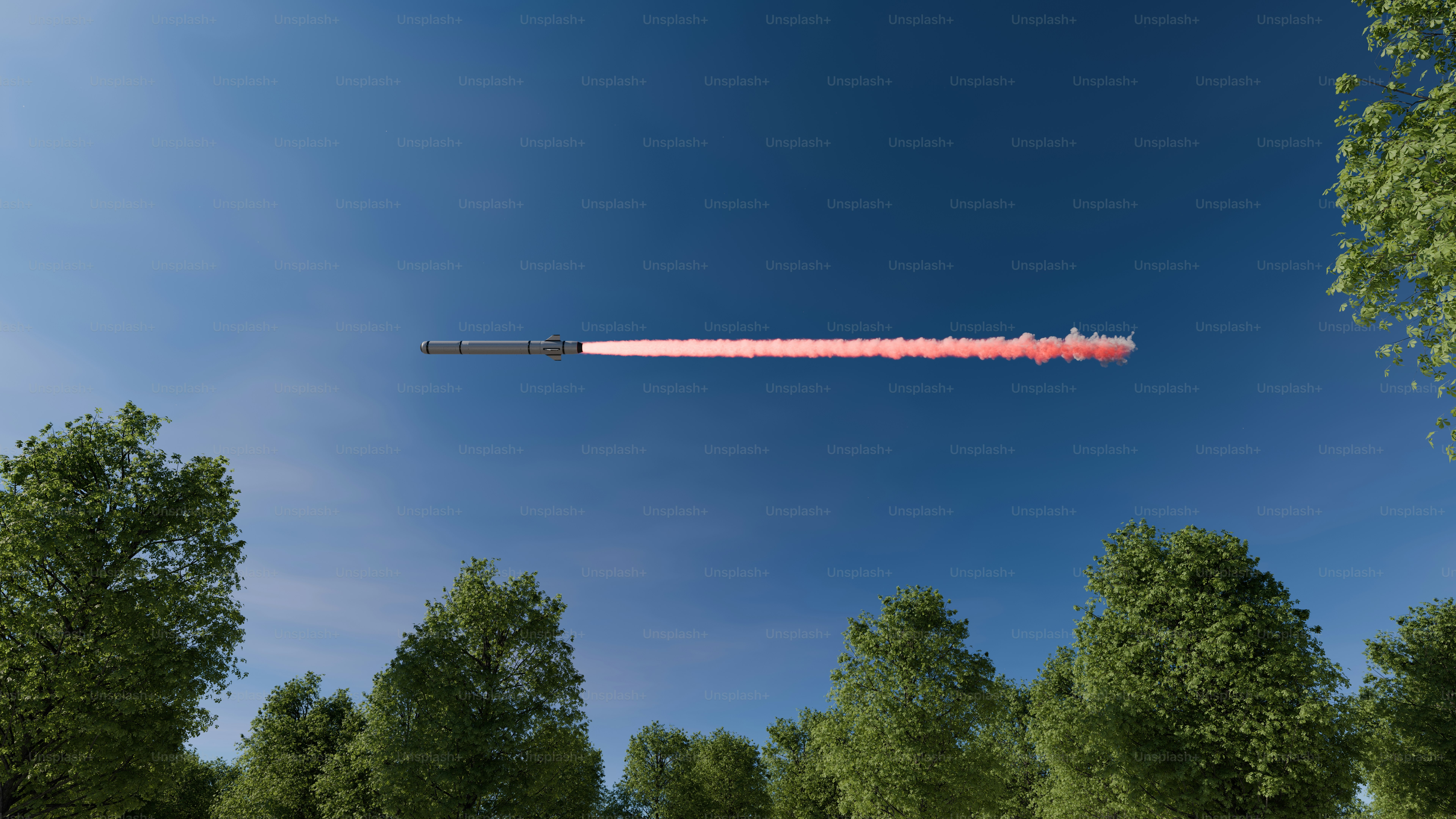 A red and white contrail flying over a lush green forest photo – 3d ...