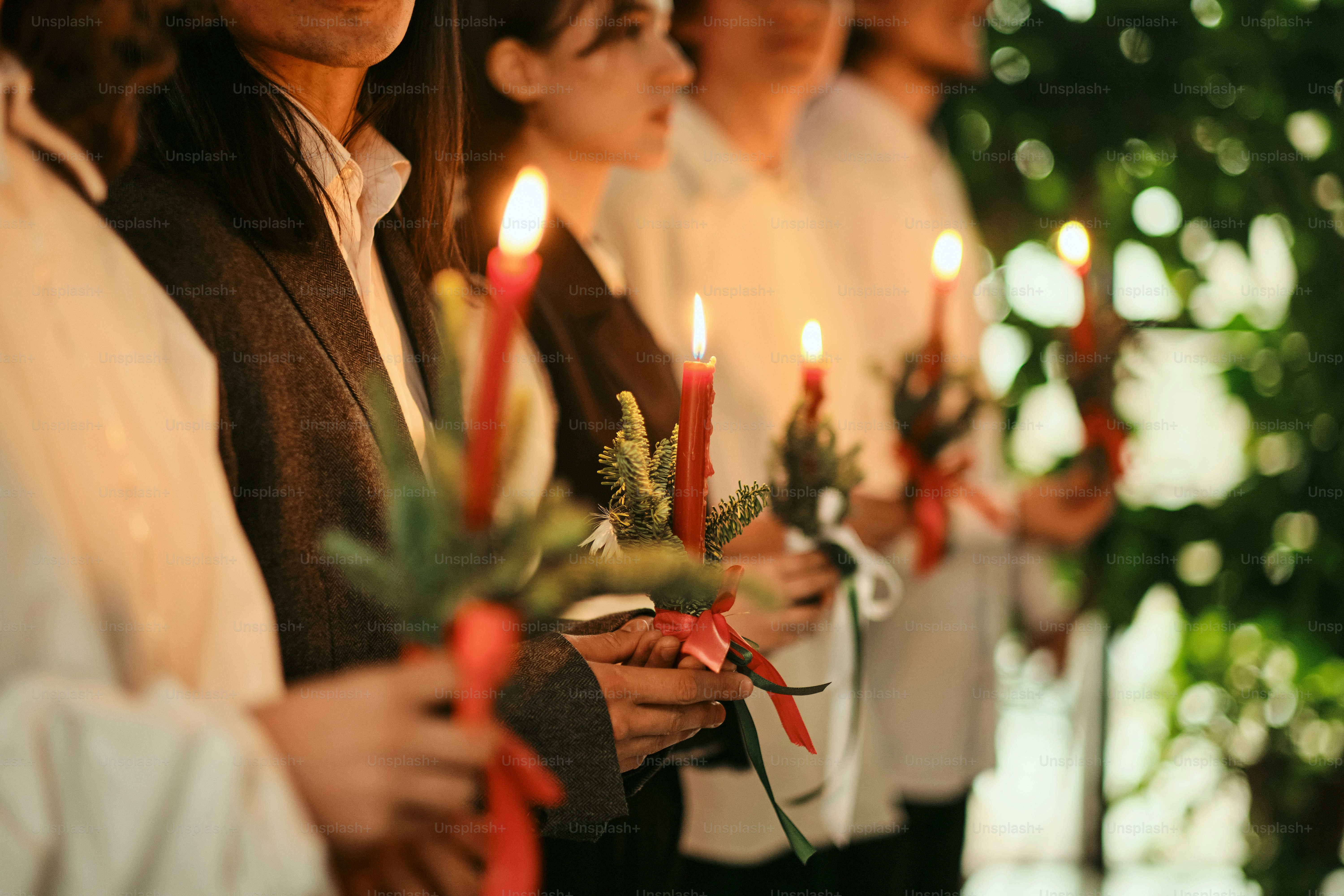 A group of people standing next to each other holding candles photo ...