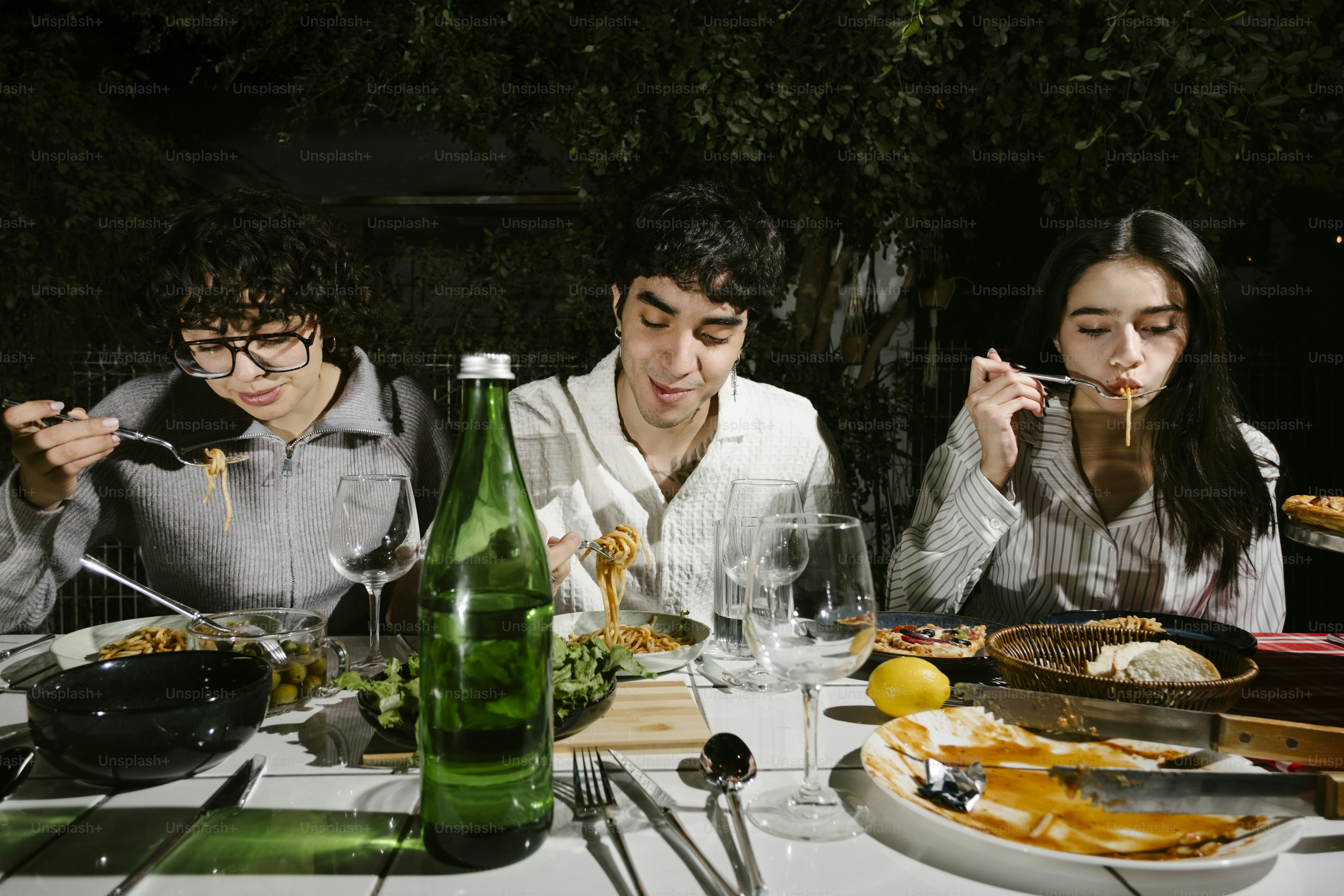 A group of people sitting around a table eating food photo ...