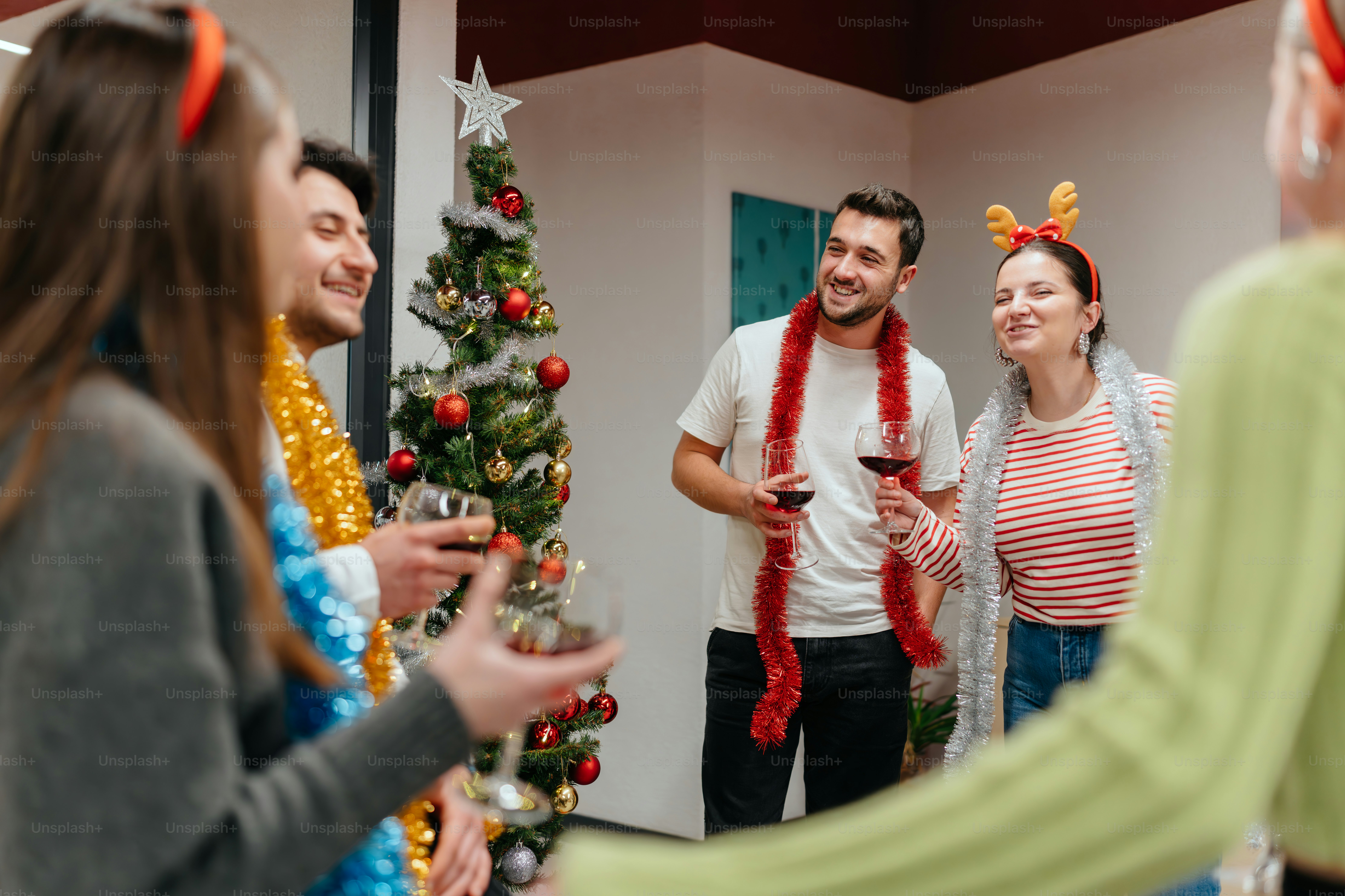 A group of people standing around a christmas tree photo – Office Image ...