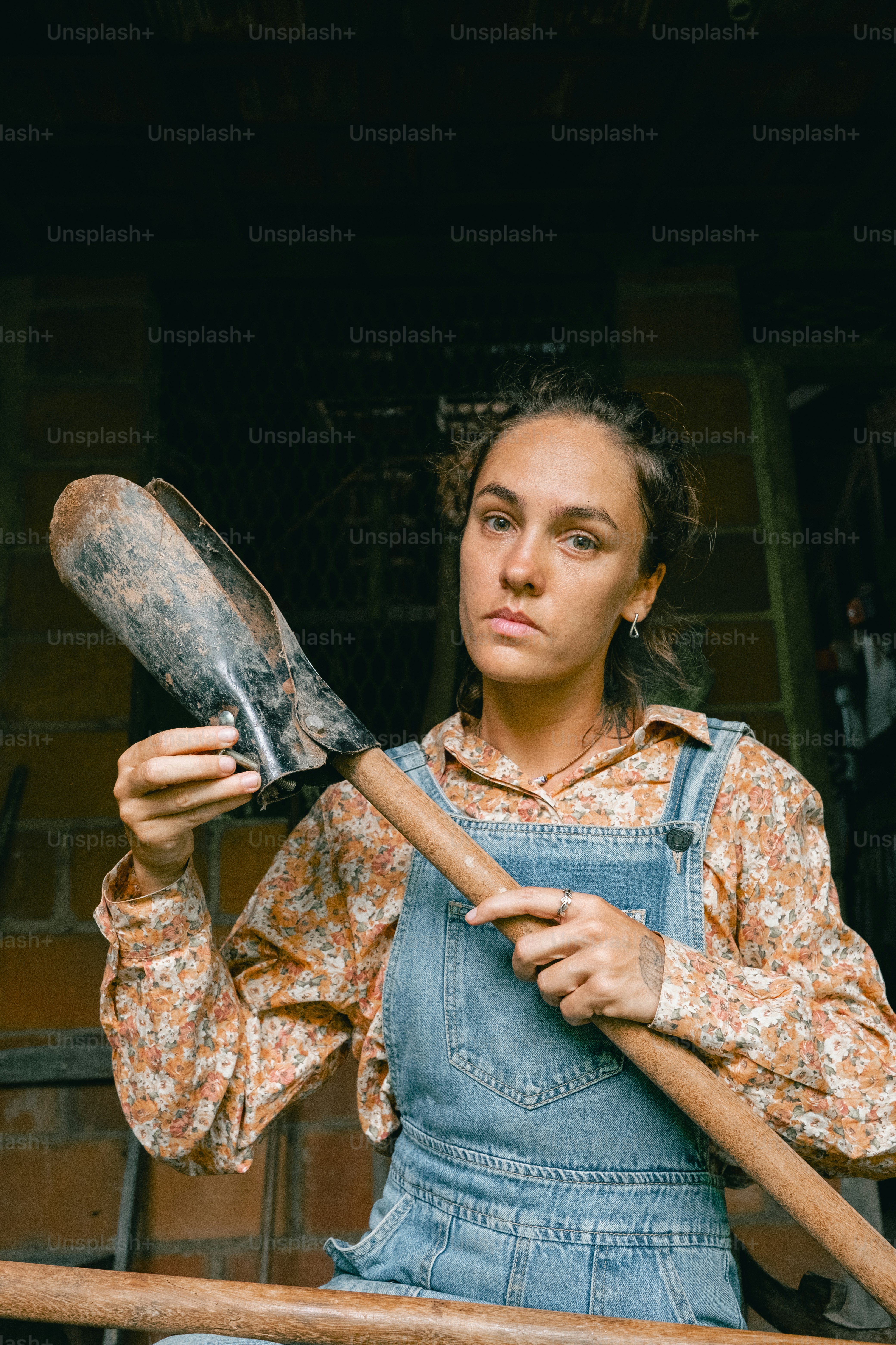 A woman in overalls holding a large wooden mallet photo – Youth Image ...