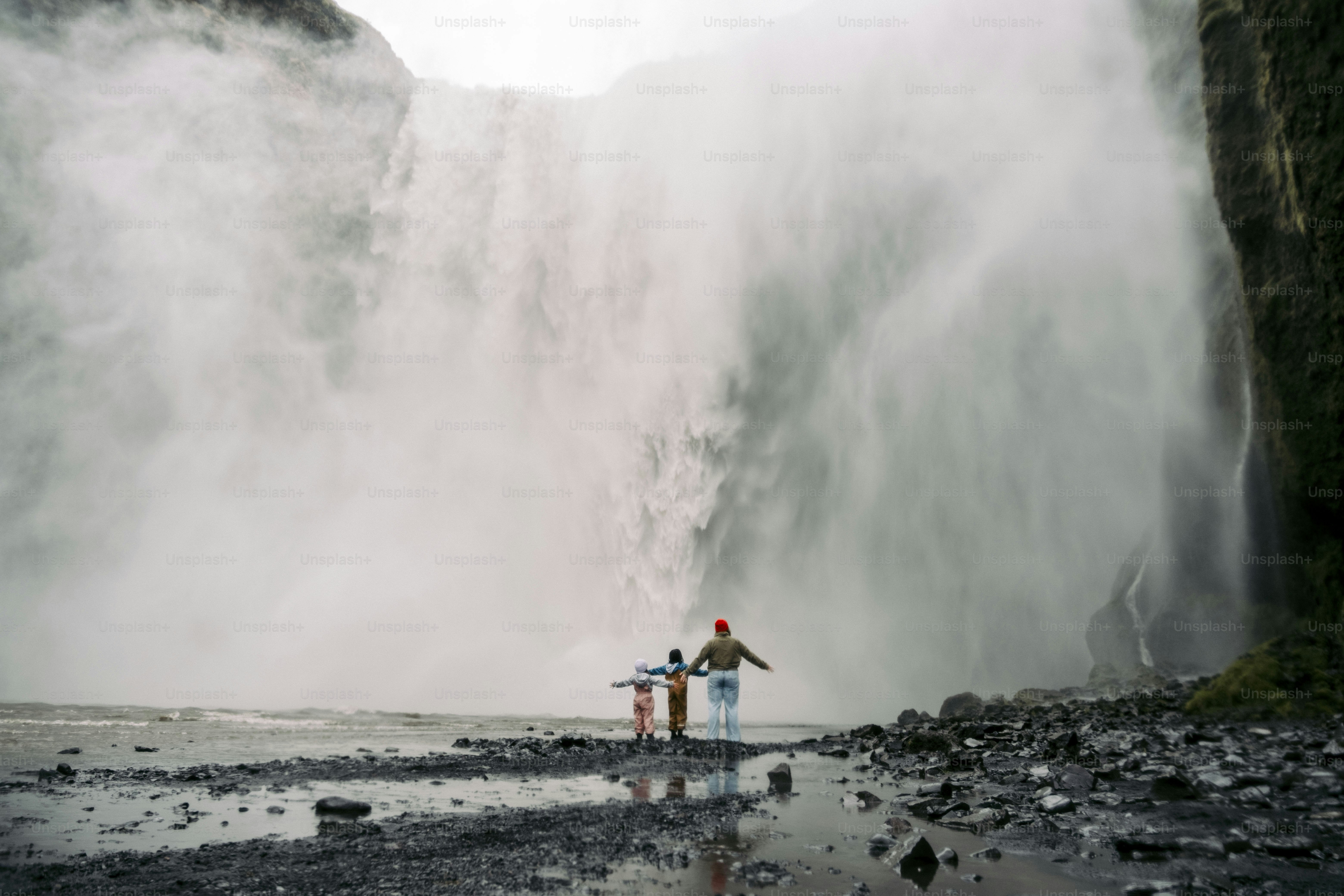 Un couple de personnes debout devant une cascade photo – Image de ...