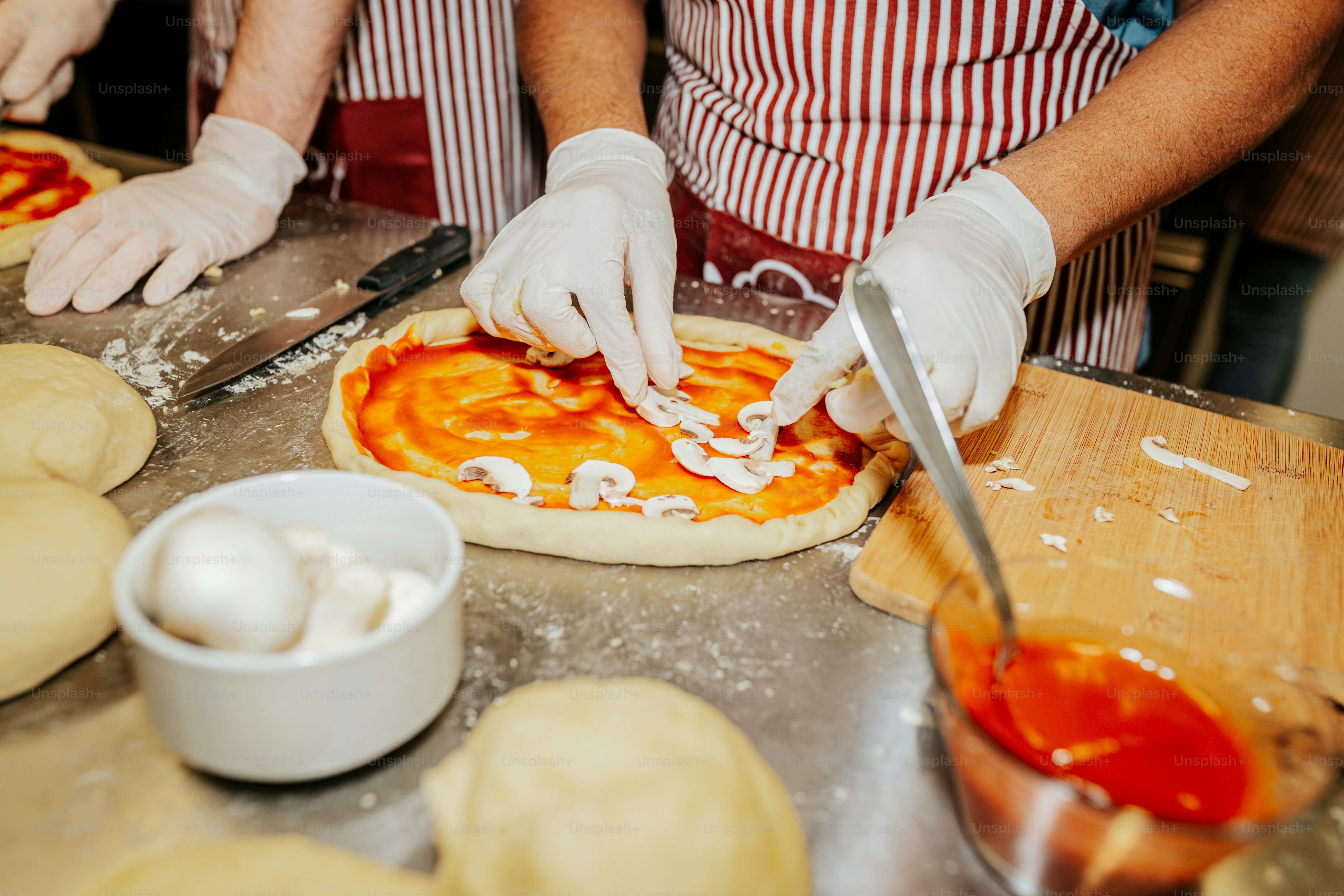 A group of people making pizzas in a kitchen photo – Food Image on Unsplash