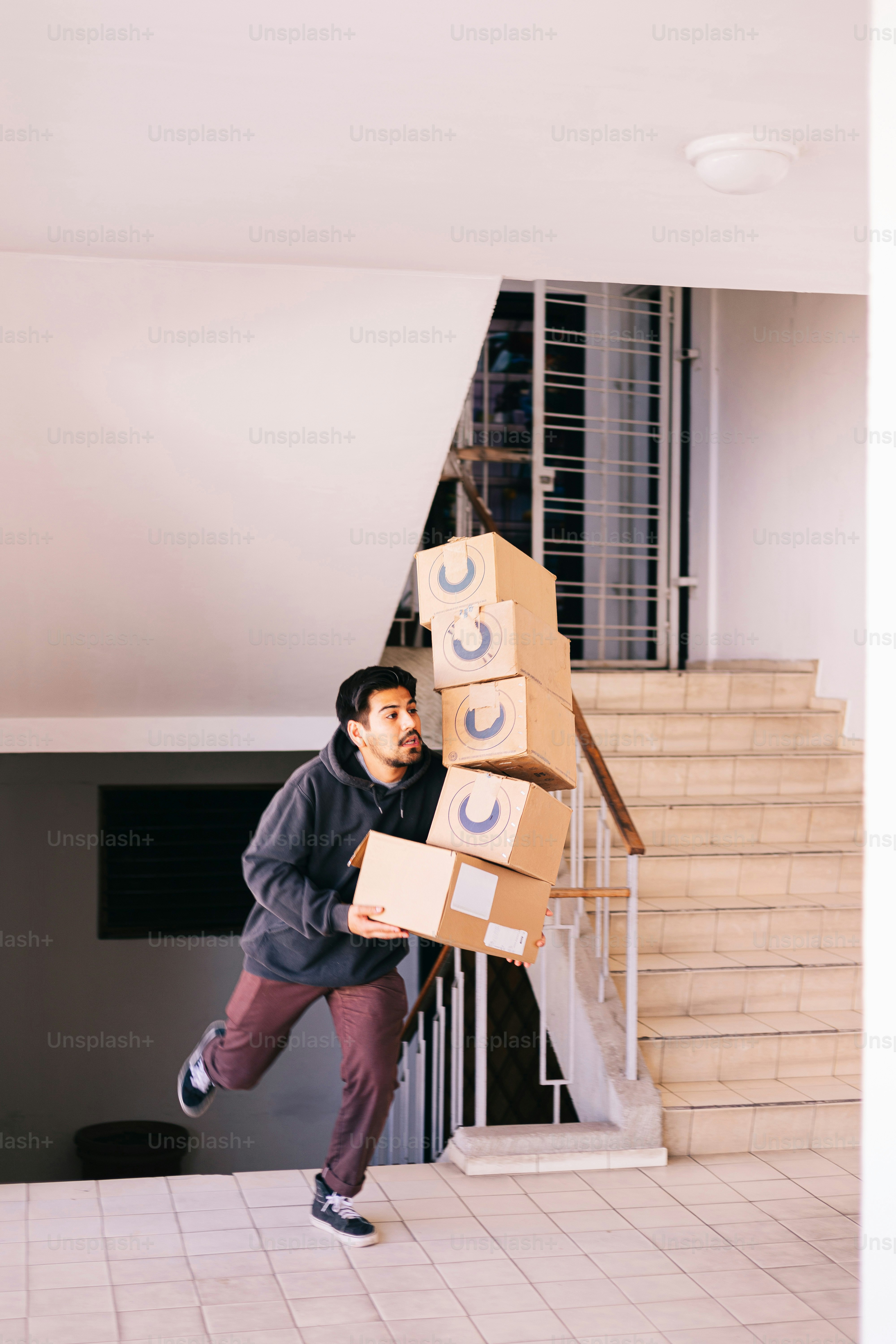 A man carrying boxes down a flight of stairs photo – Humour Image on ...