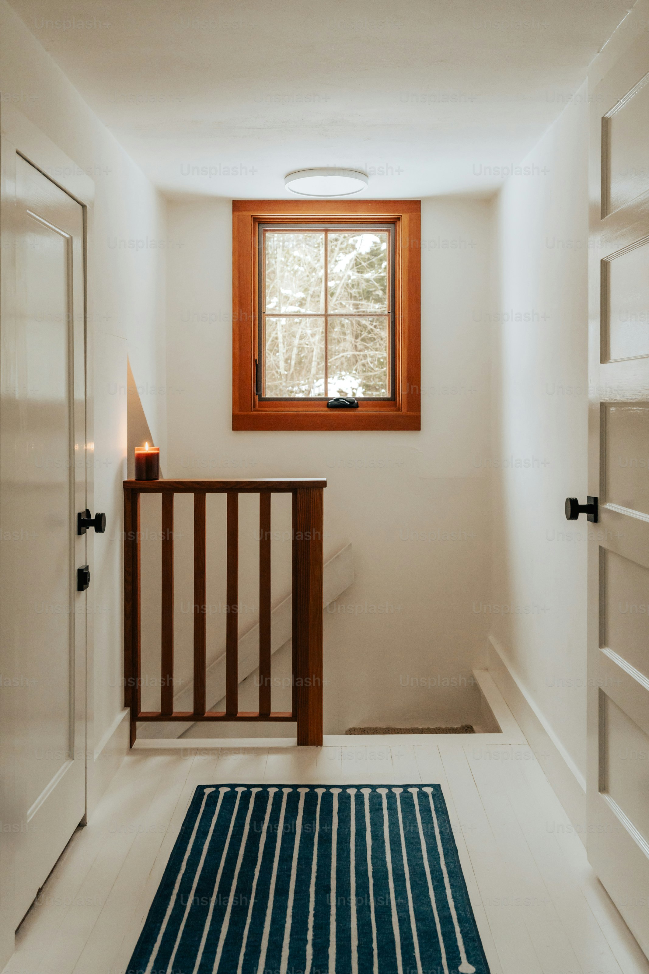 A hallway with a blue rug and a window photo – Building Image on Unsplash