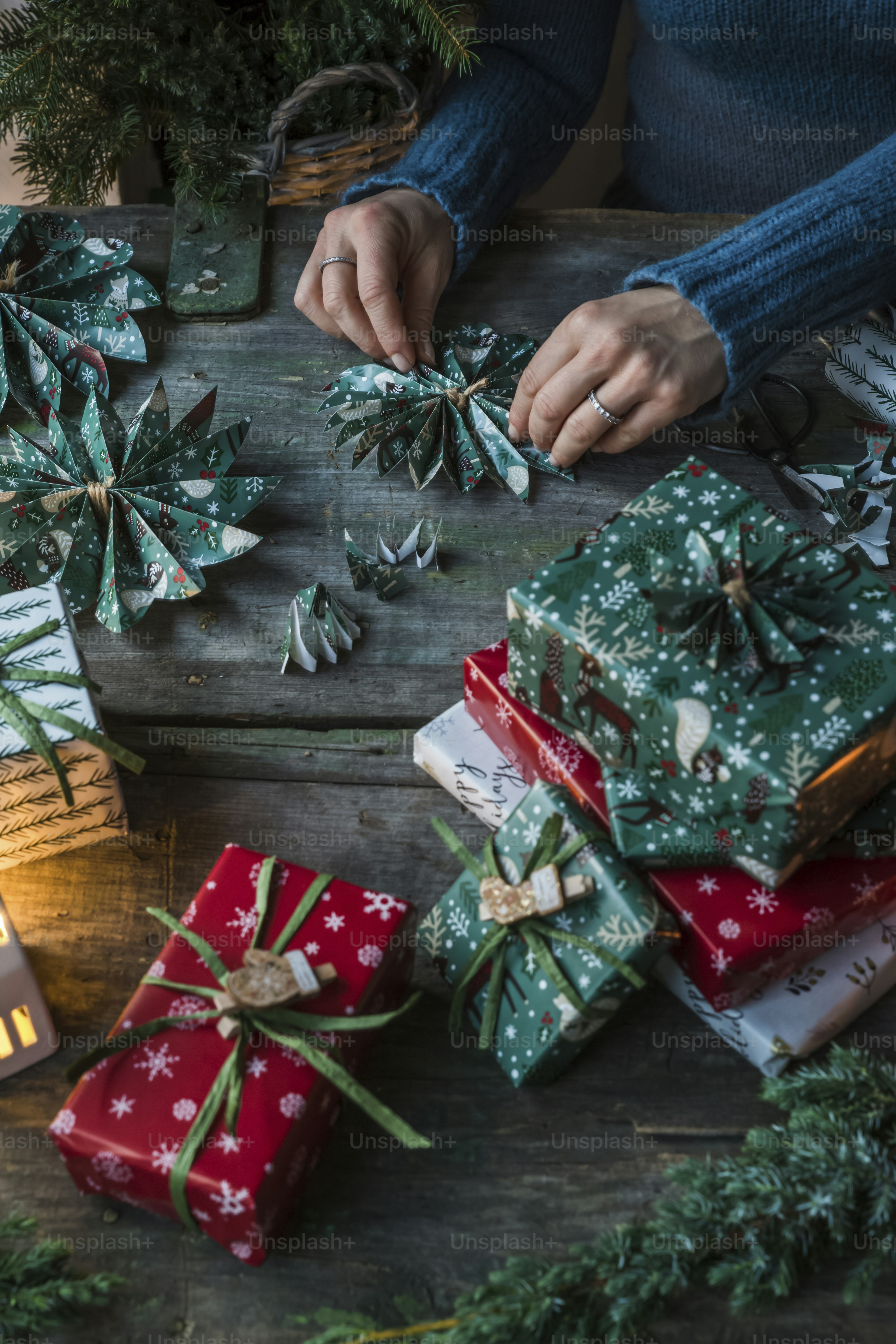 A person wrapping presents under a christmas tree photo – Christmas ...