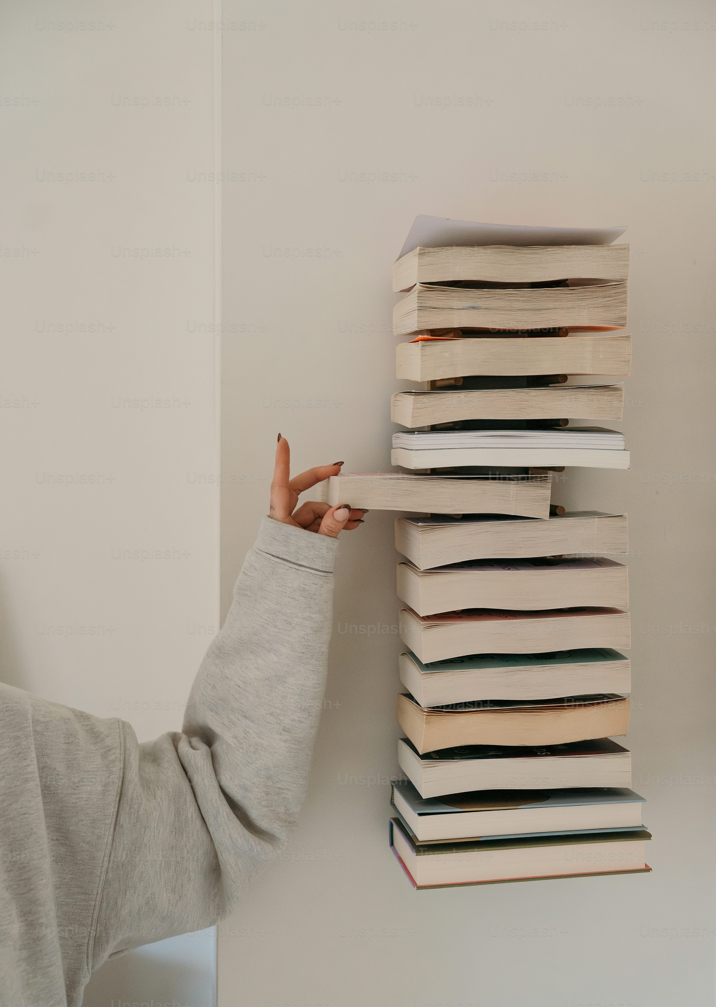 Una persona che si avvicina a una pila di libri foto – Immagine di ... Una persona che si avvicina a una pila di libri foto – Immagine di ...