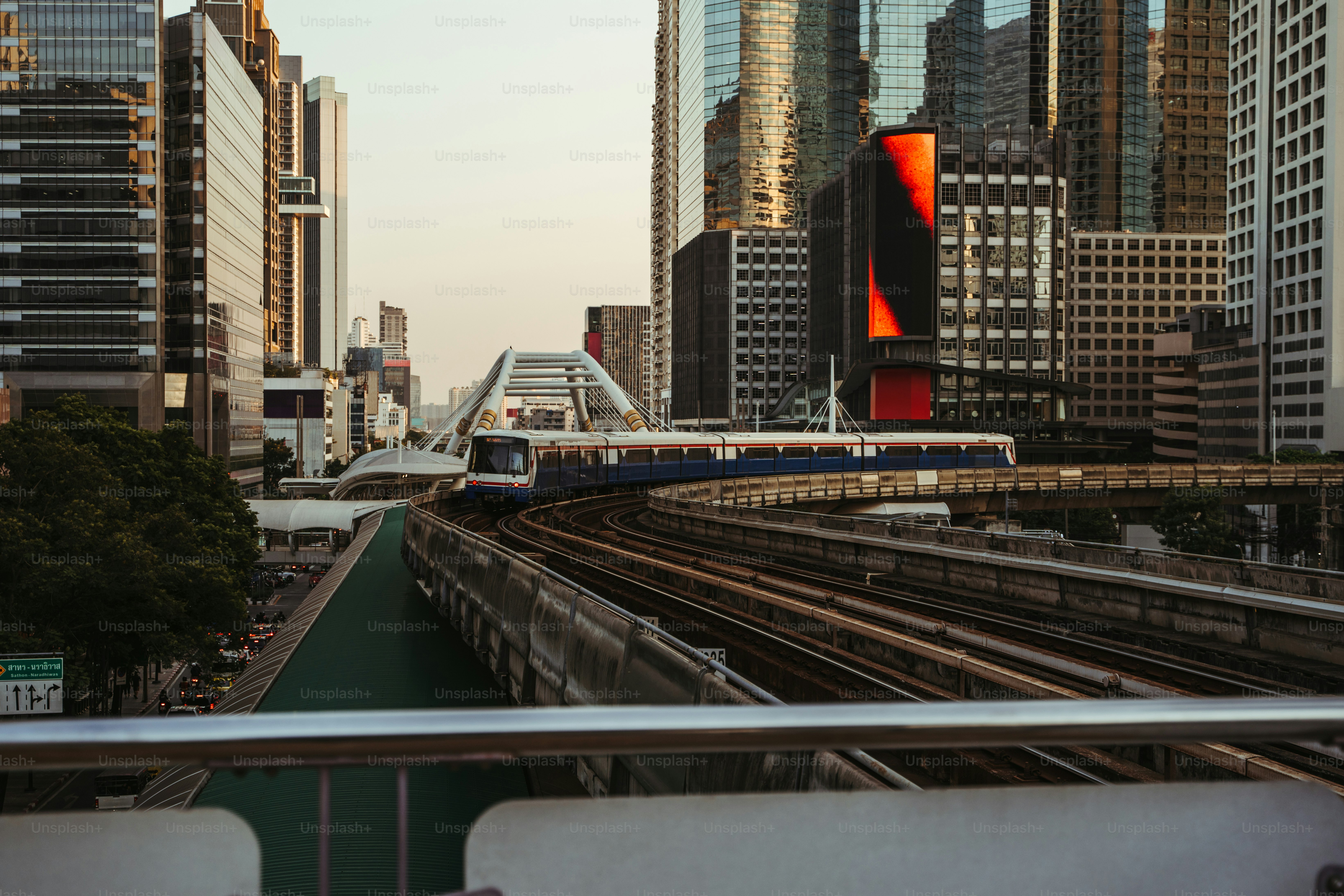 A train traveling through a city next to tall buildings photo ...