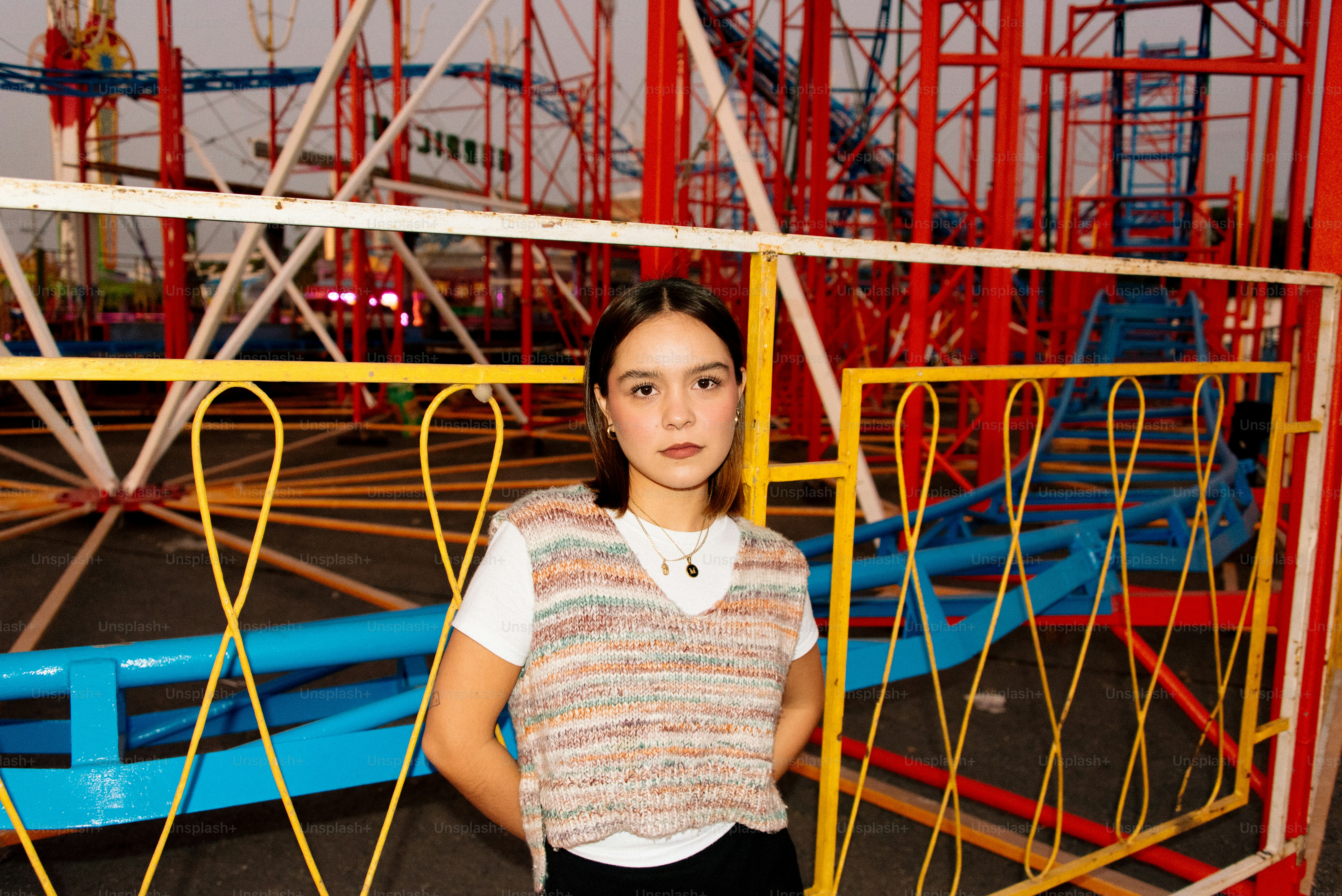 A woman standing in front of a carnival ride photo – Portrait Image on ...