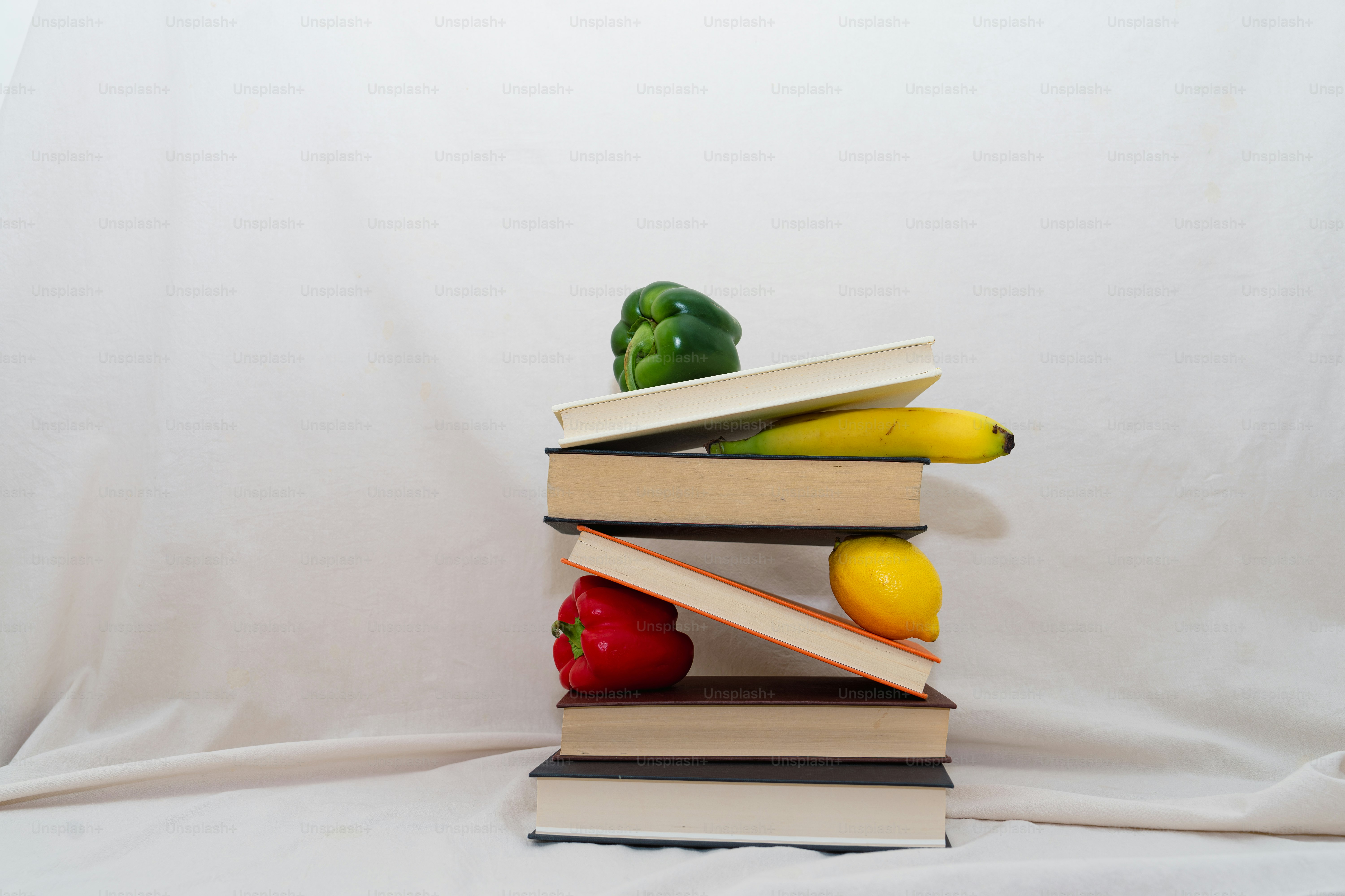 A stack of books with fruits and vegetables on top photo – Books Image ...
