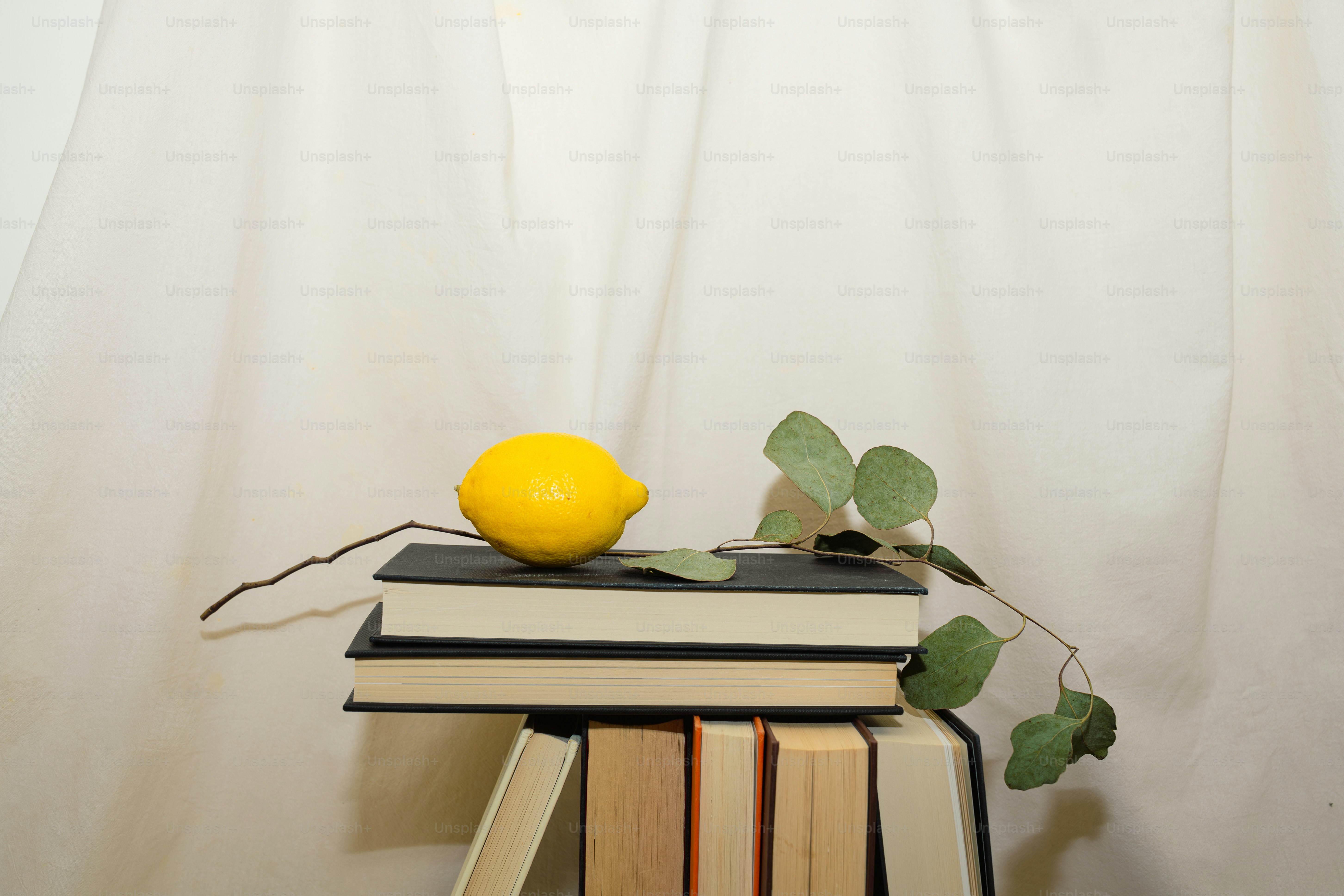 A lemon sitting on top of a stack of books photo – Image on Unsplash