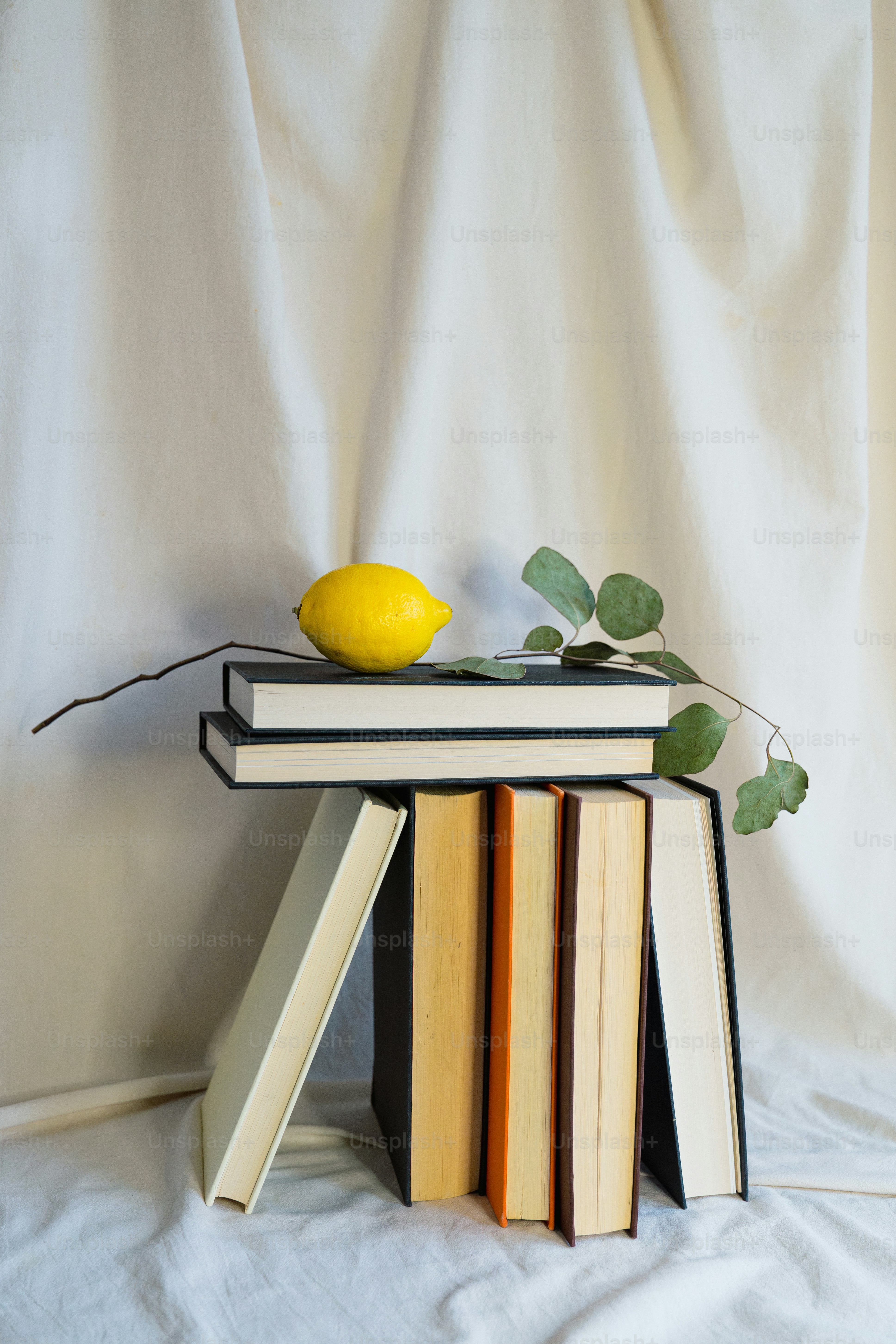A stack of books with a lemon on top photo – Books Image on Unsplash