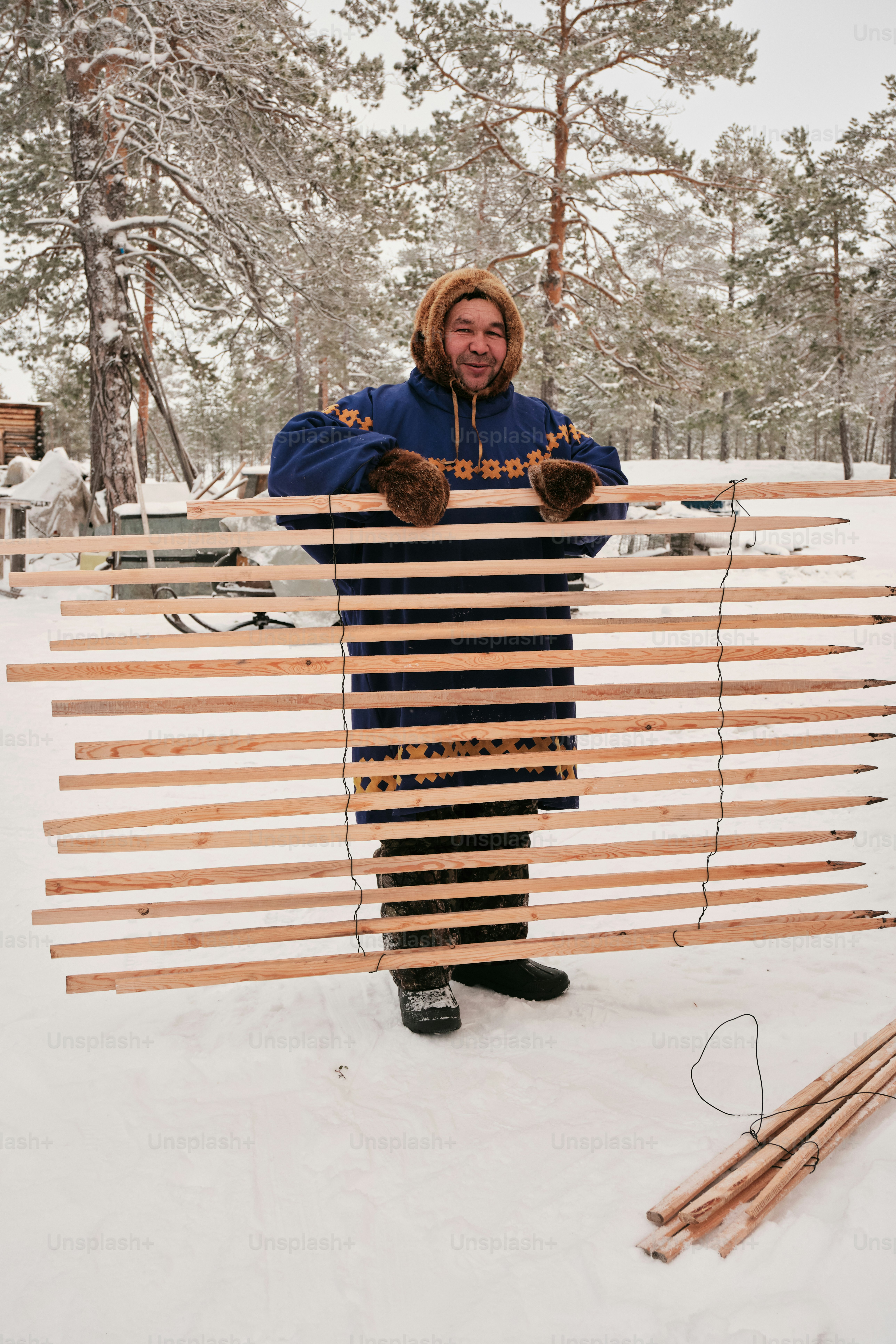A man standing in the snow holding a sled photo – Real people Image on ...