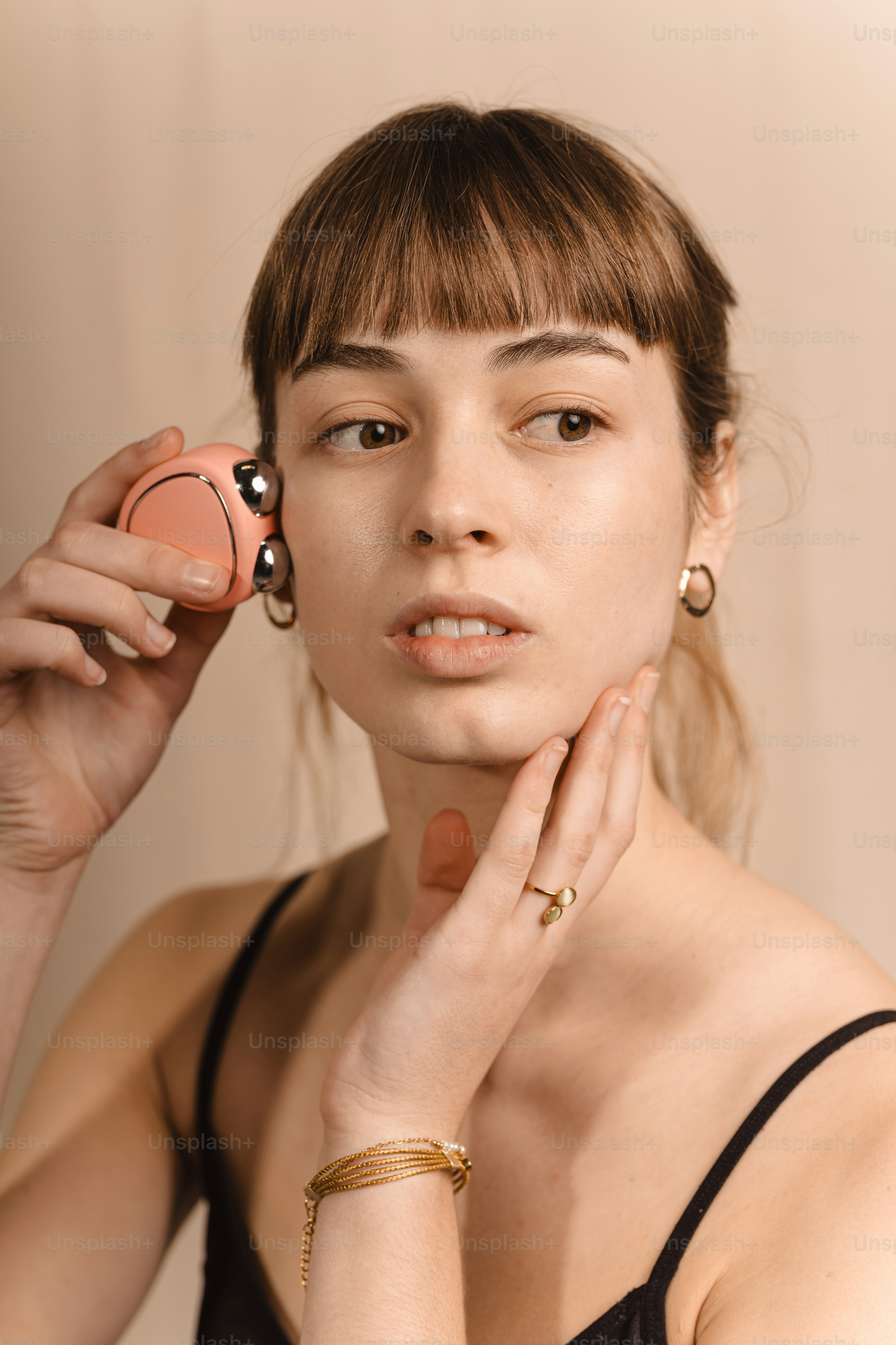 A woman holding an object up to her face photo – Skin Image on Unsplash