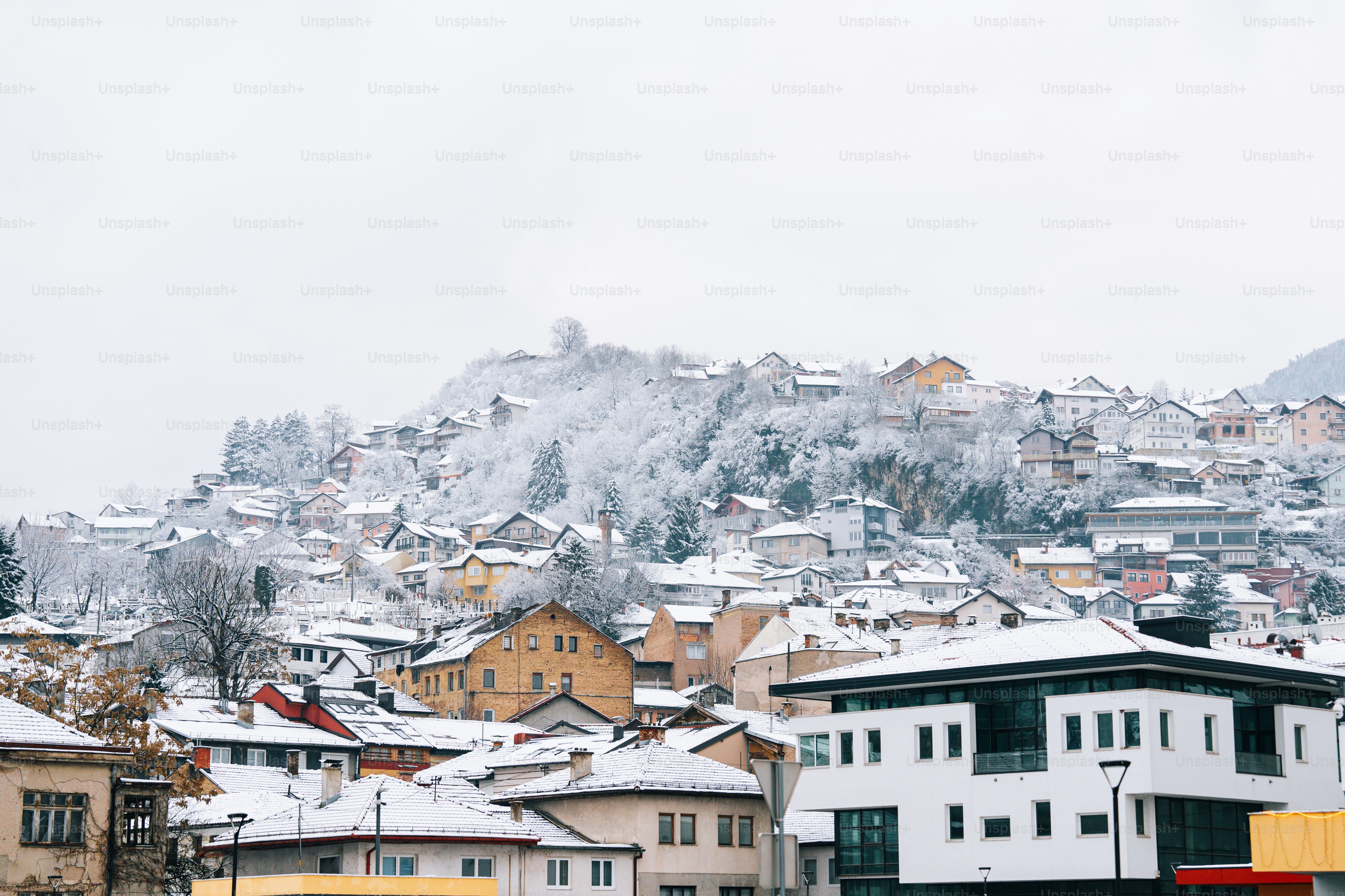 A snow covered town with a mountain in the background photo – Winter ...