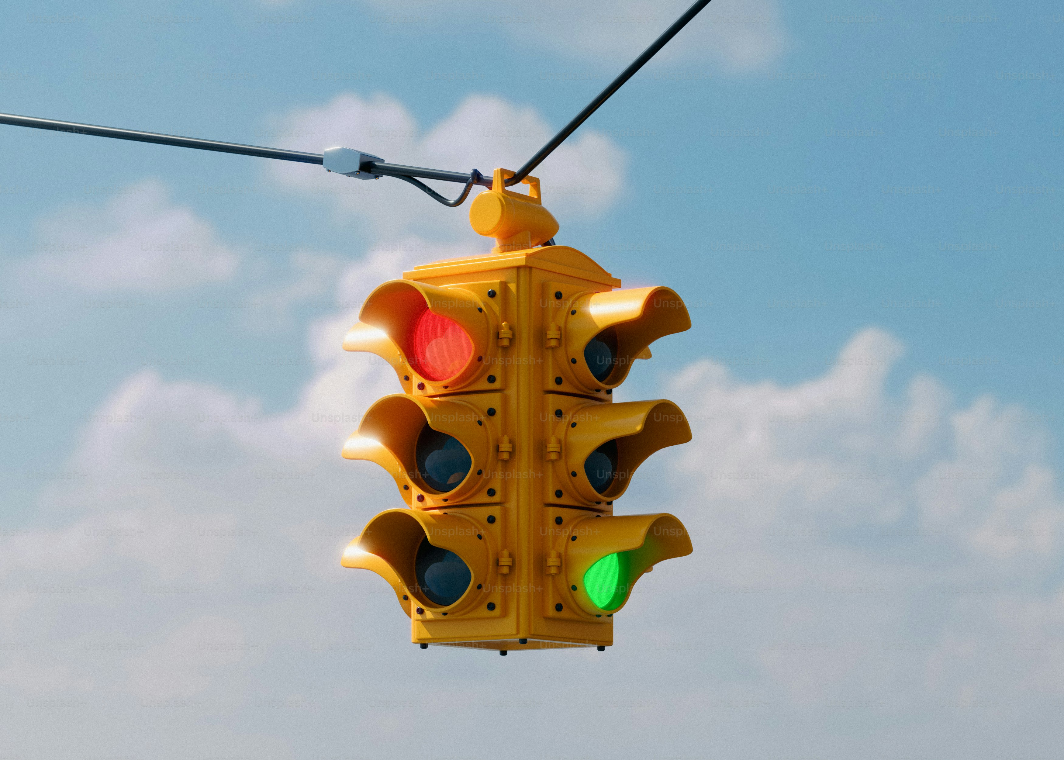A traffic light hanging from a wire with a sky background photo ...