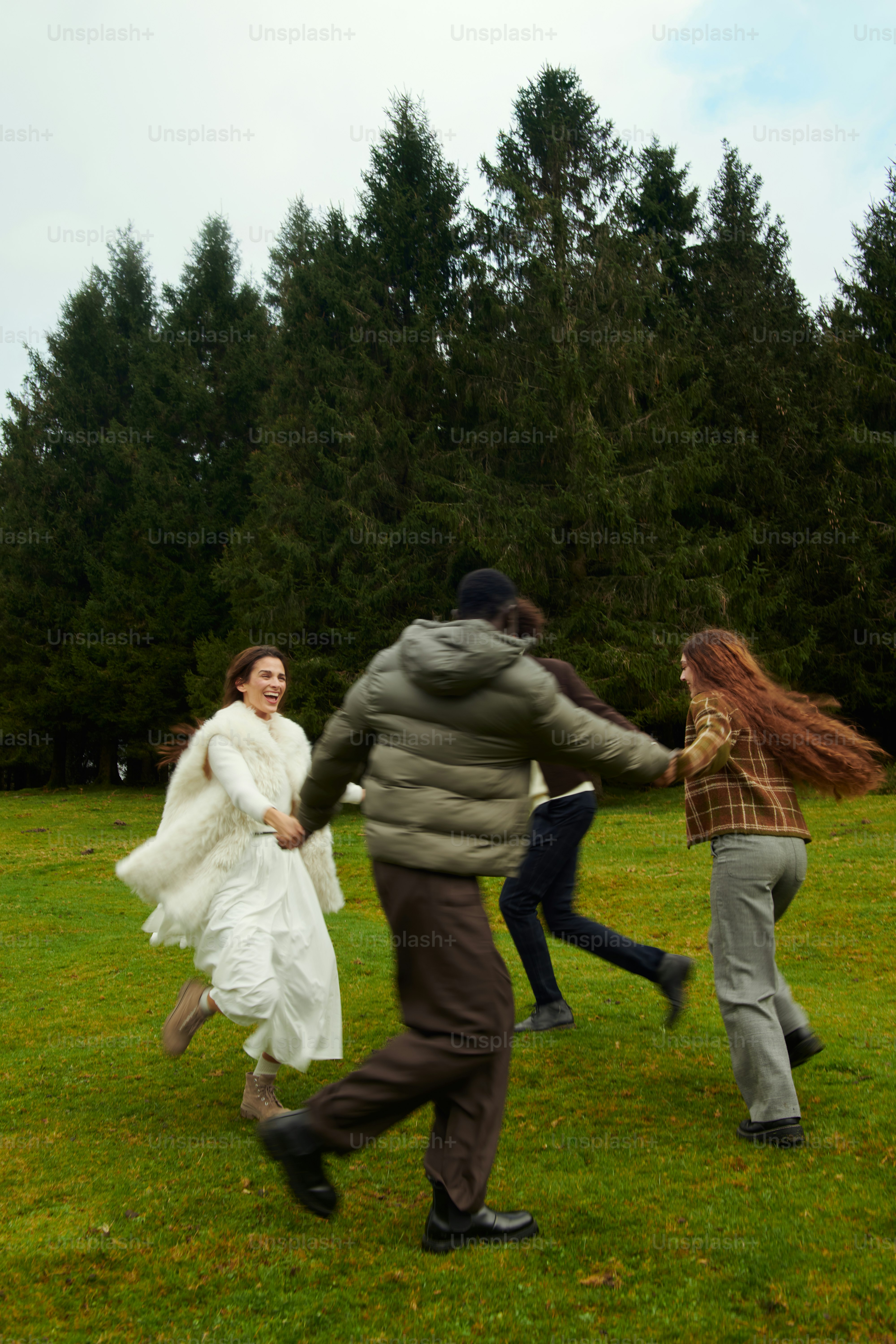 A group of people running across a grass covered field photo – Hiking ...