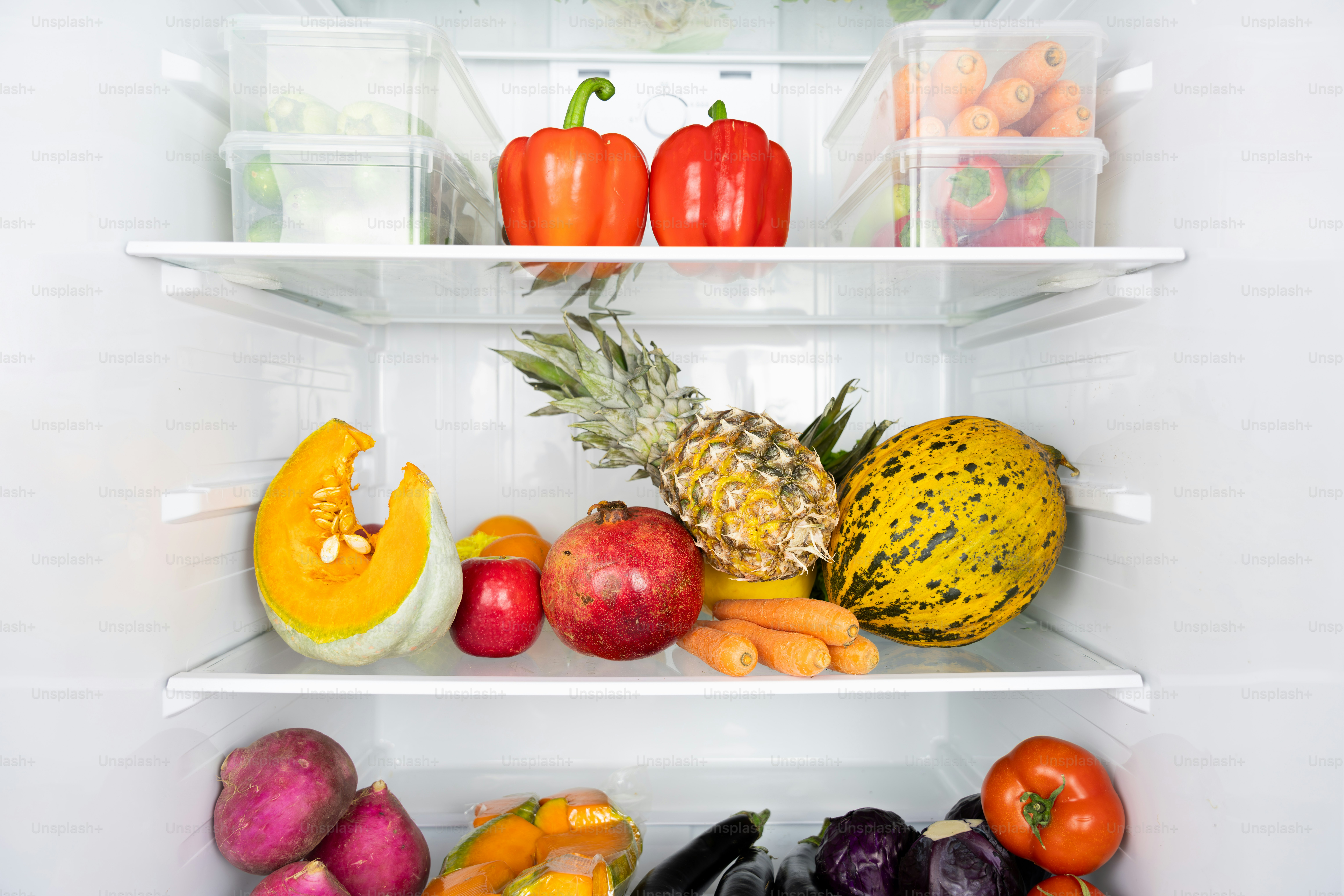 Un refrigerador lleno de muchos tipos diferentes de frutas y verduras ...