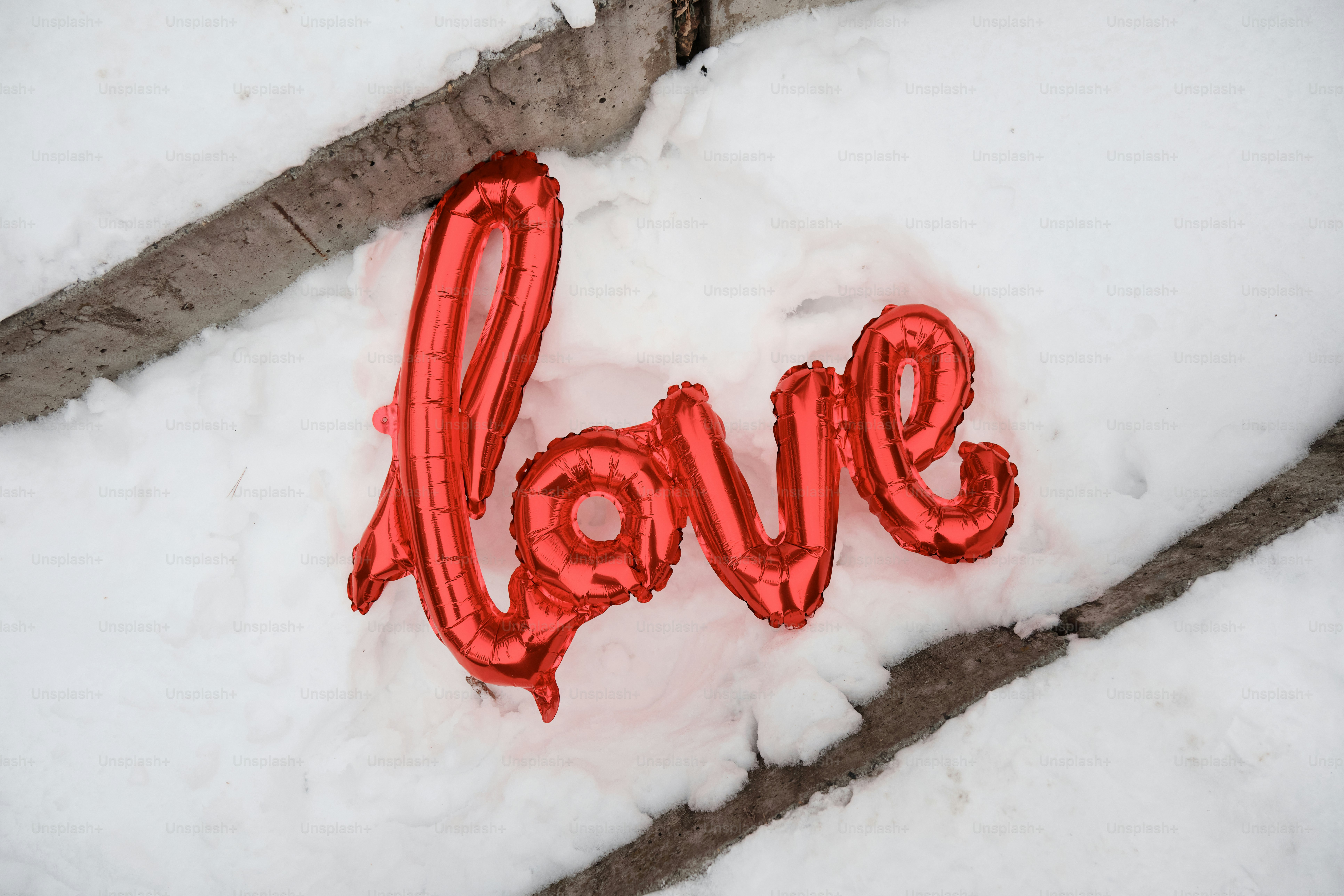 A red balloon that says love in the snow photo – Love Image on Unsplash