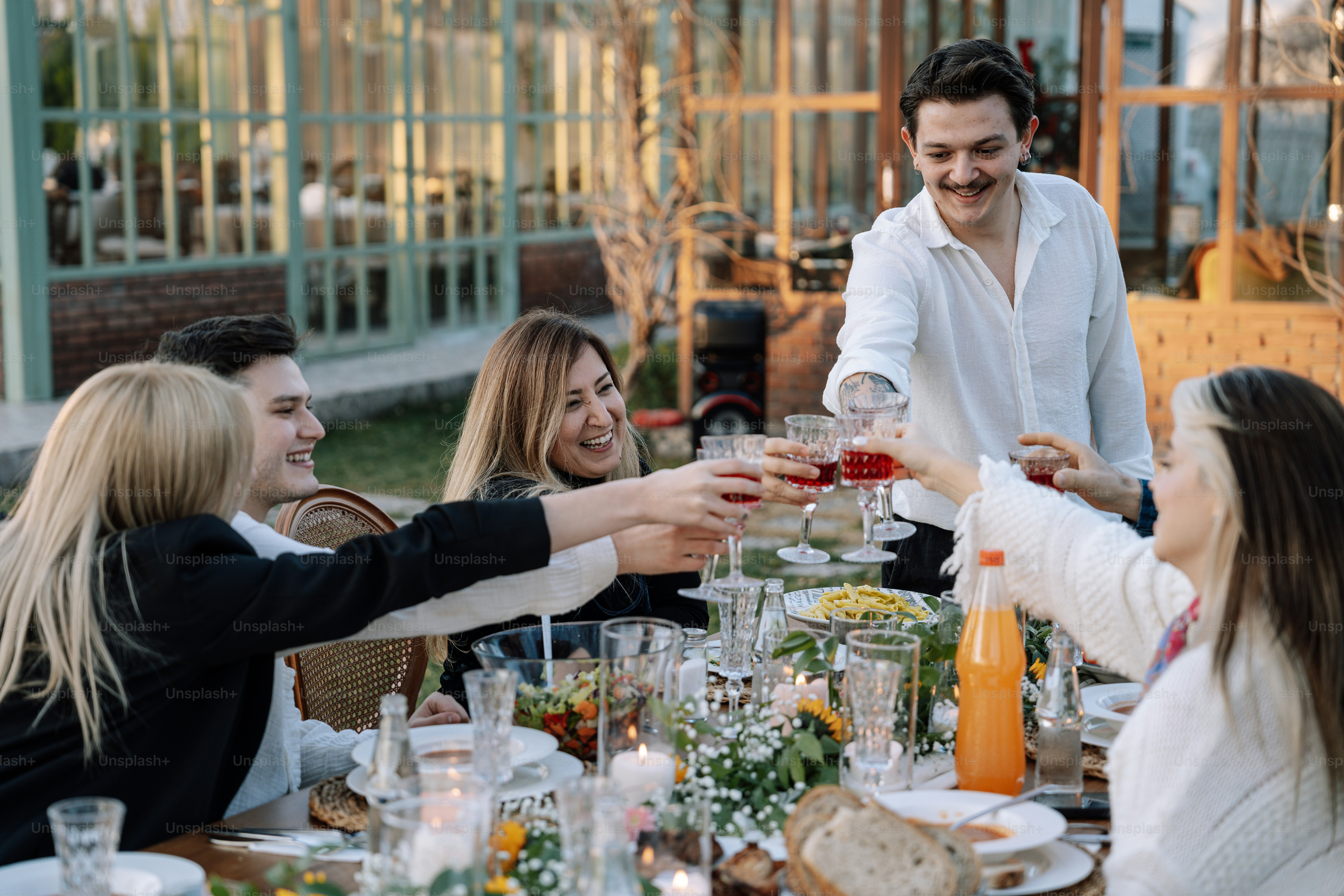 A group of people sitting around a wooden table photo – Dinner Image on ...