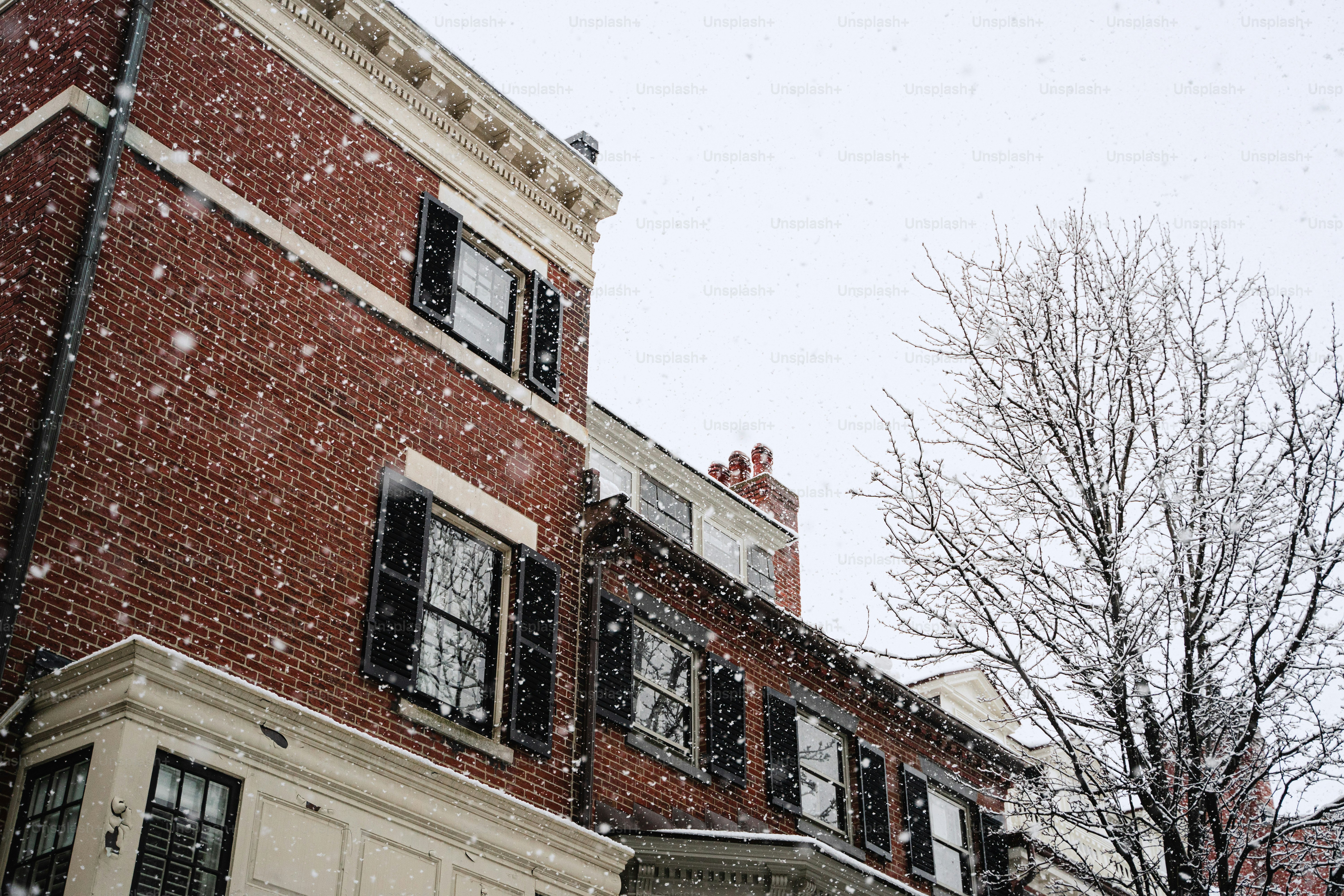 A red brick building with snow falling on it photo – Urban Image on ...