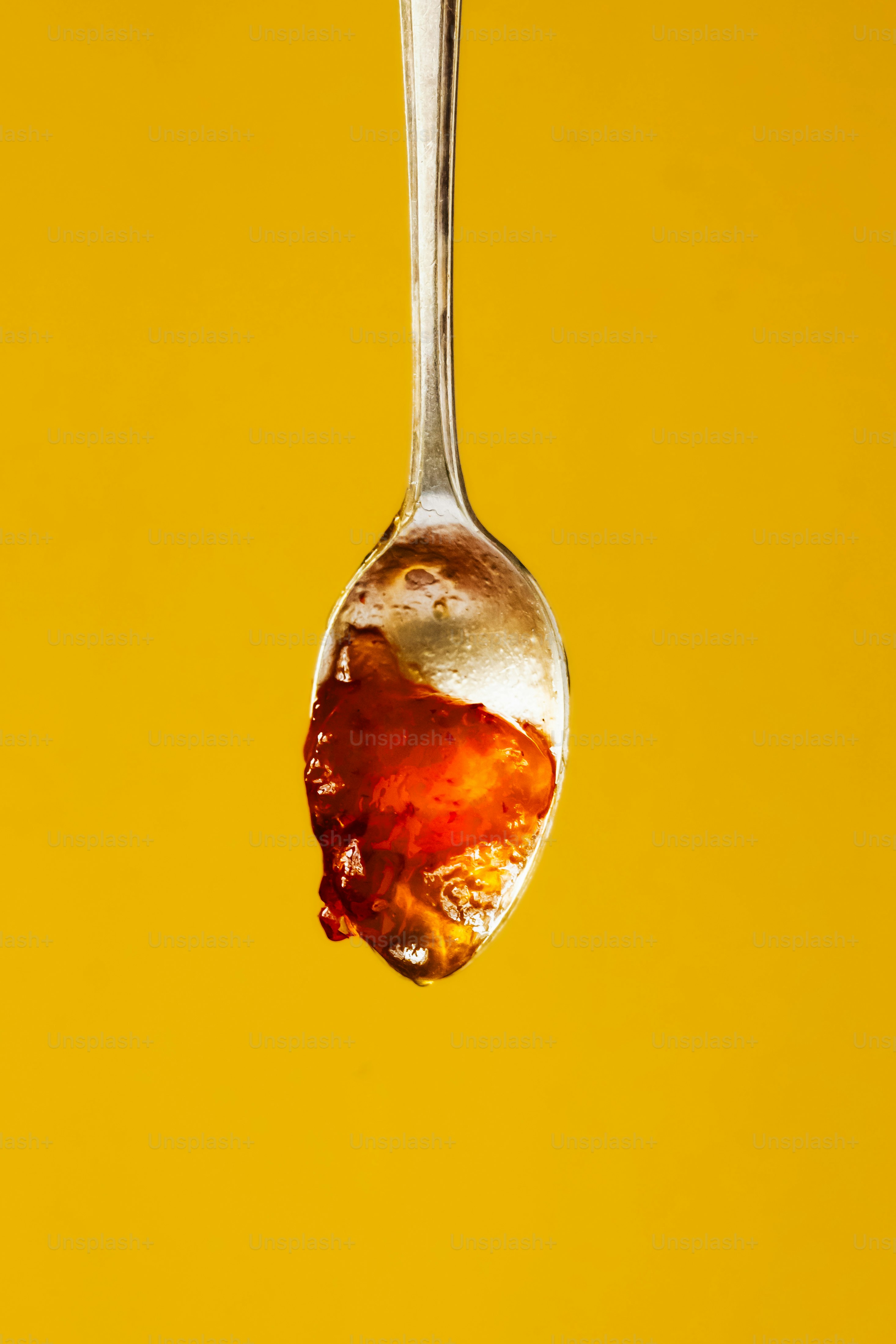 A spoon with a drop of syrup on it photo – Spoonful Image on Unsplash