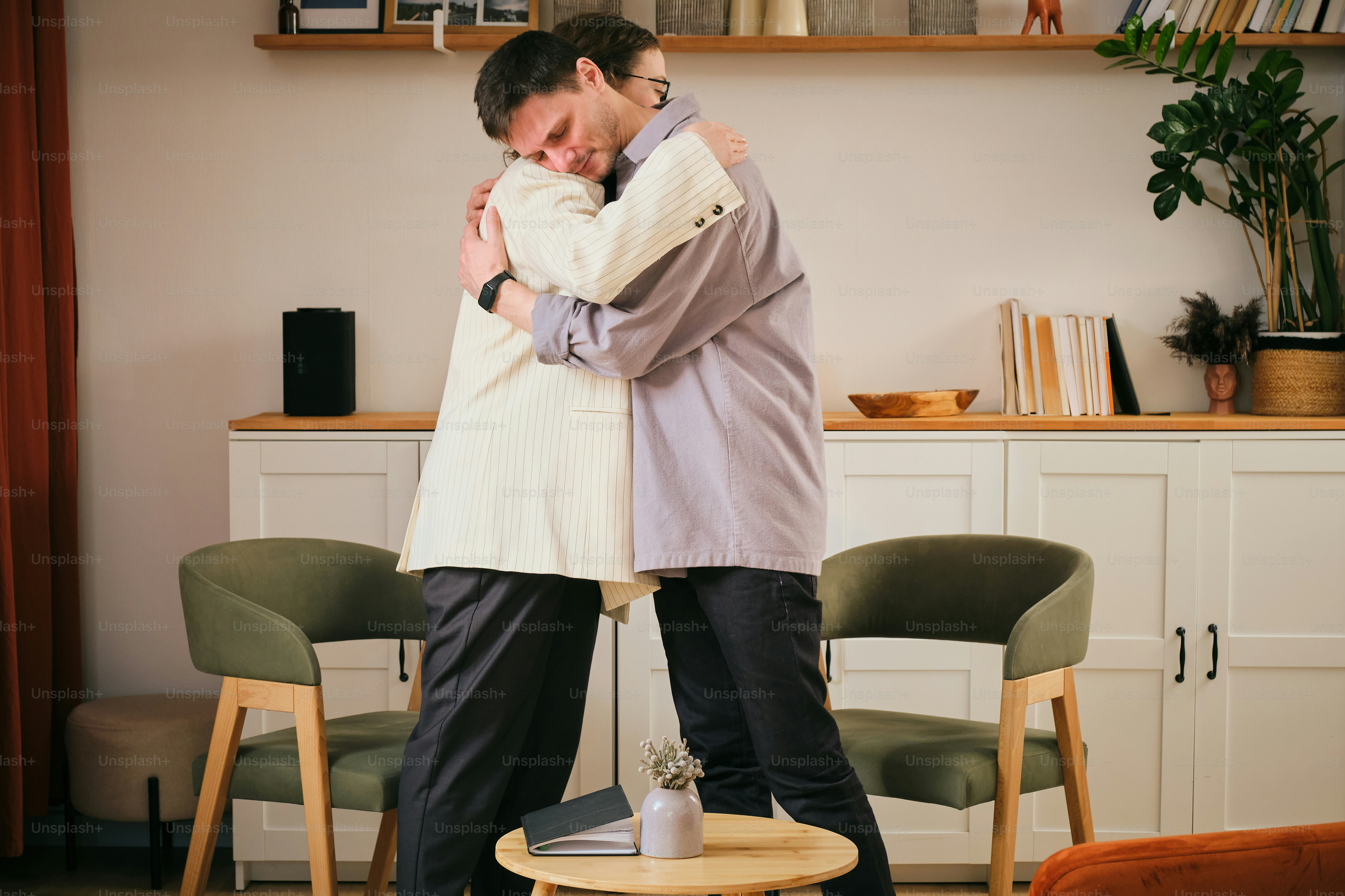 A couple of men standing next to each other in a living room photo ...