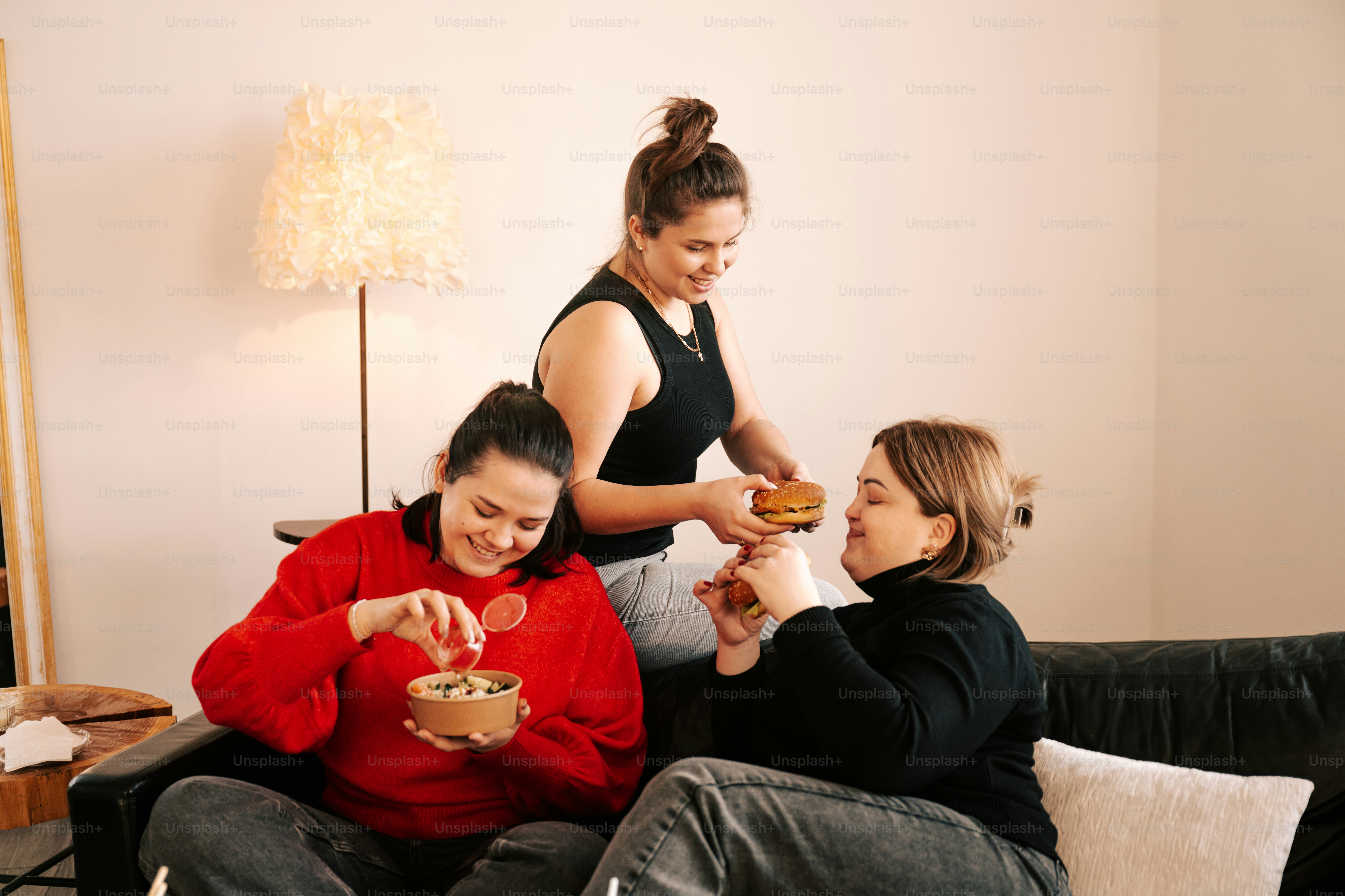 A group of people sitting on a couch eating food photo – Takeout food ...