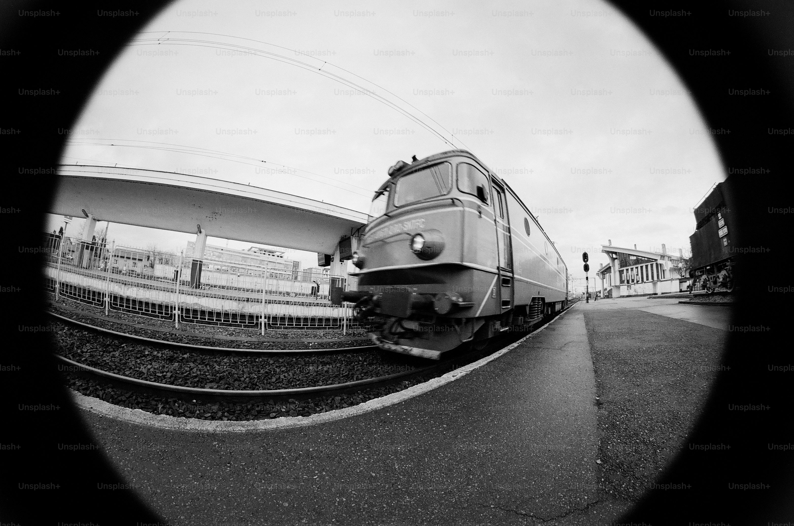 A train traveling down train tracks next to a train station photo ...