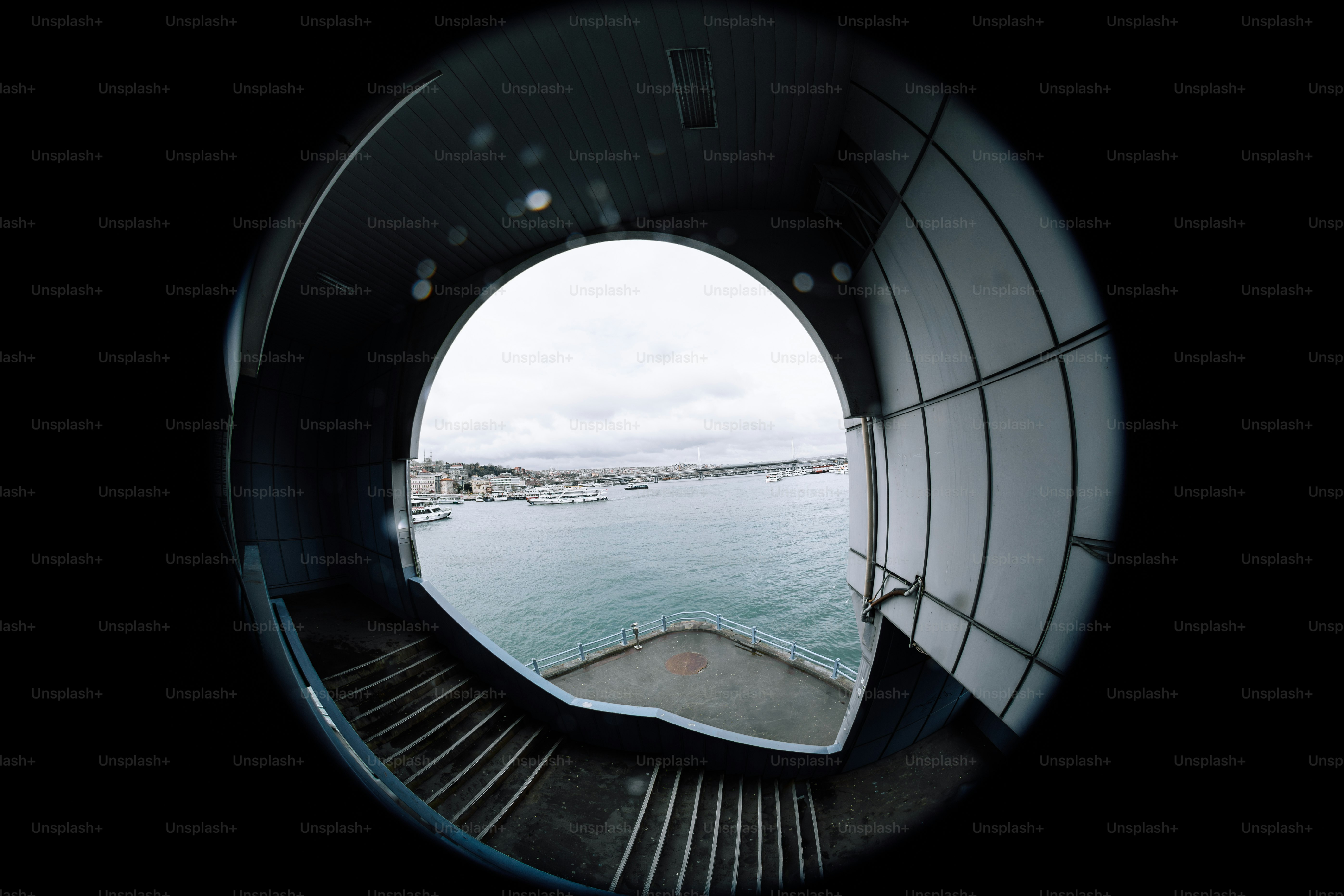 A view of a body of water through a circular window photo – Distorted ...